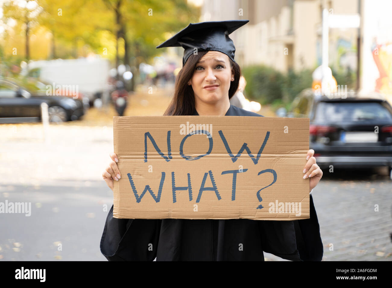Sad Graduate Student Standing With Now What Placard On Street Stock ...
