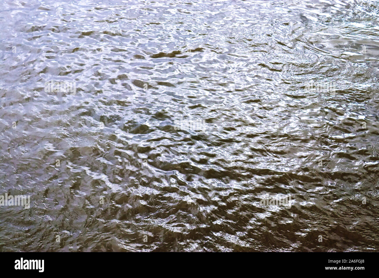 Detailed close up view on reflective water surface with waves and ...