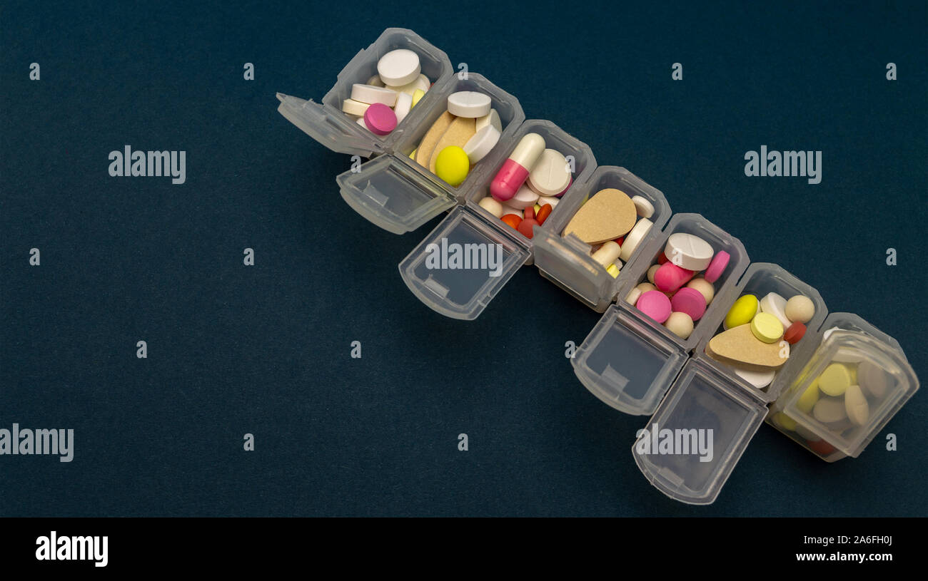 plastic organizer for tablets. tablets are red, white, round. close-up ...