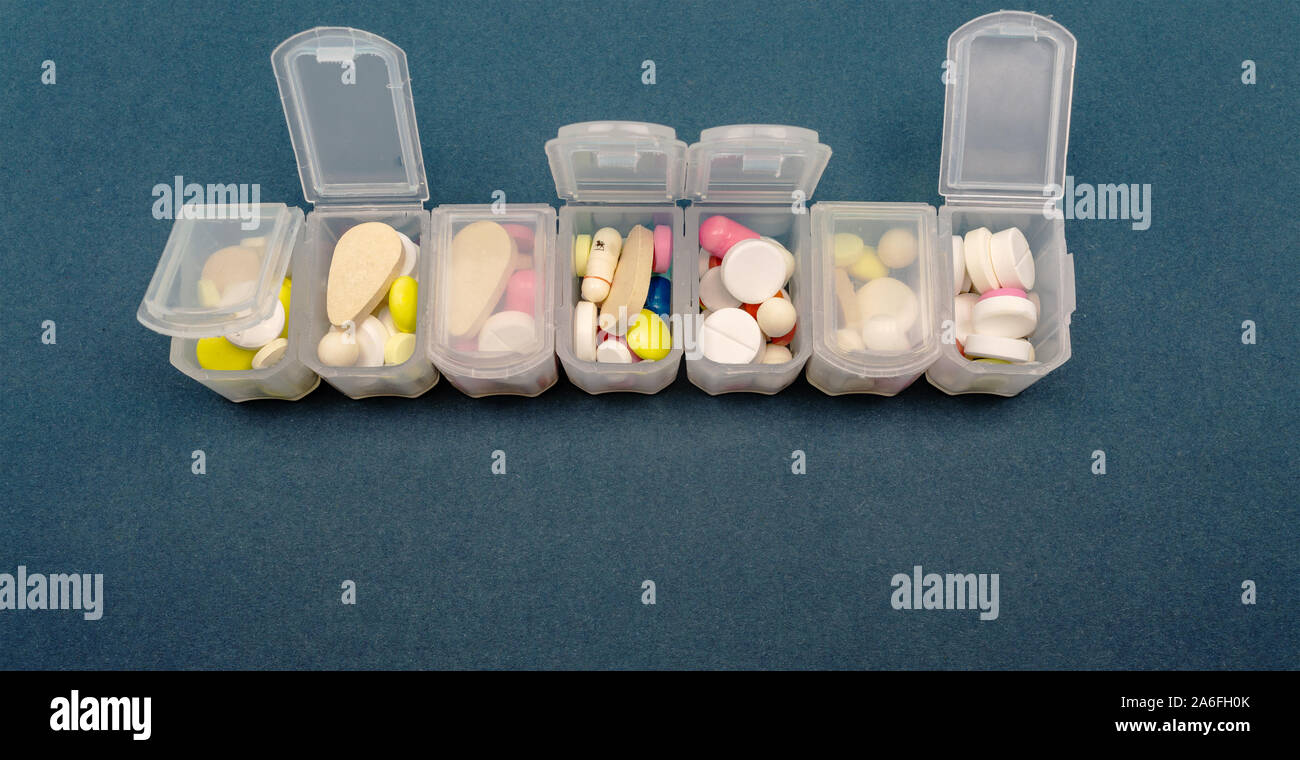 plastic organizer for tablets. tablets are red, white, round. close-up ...