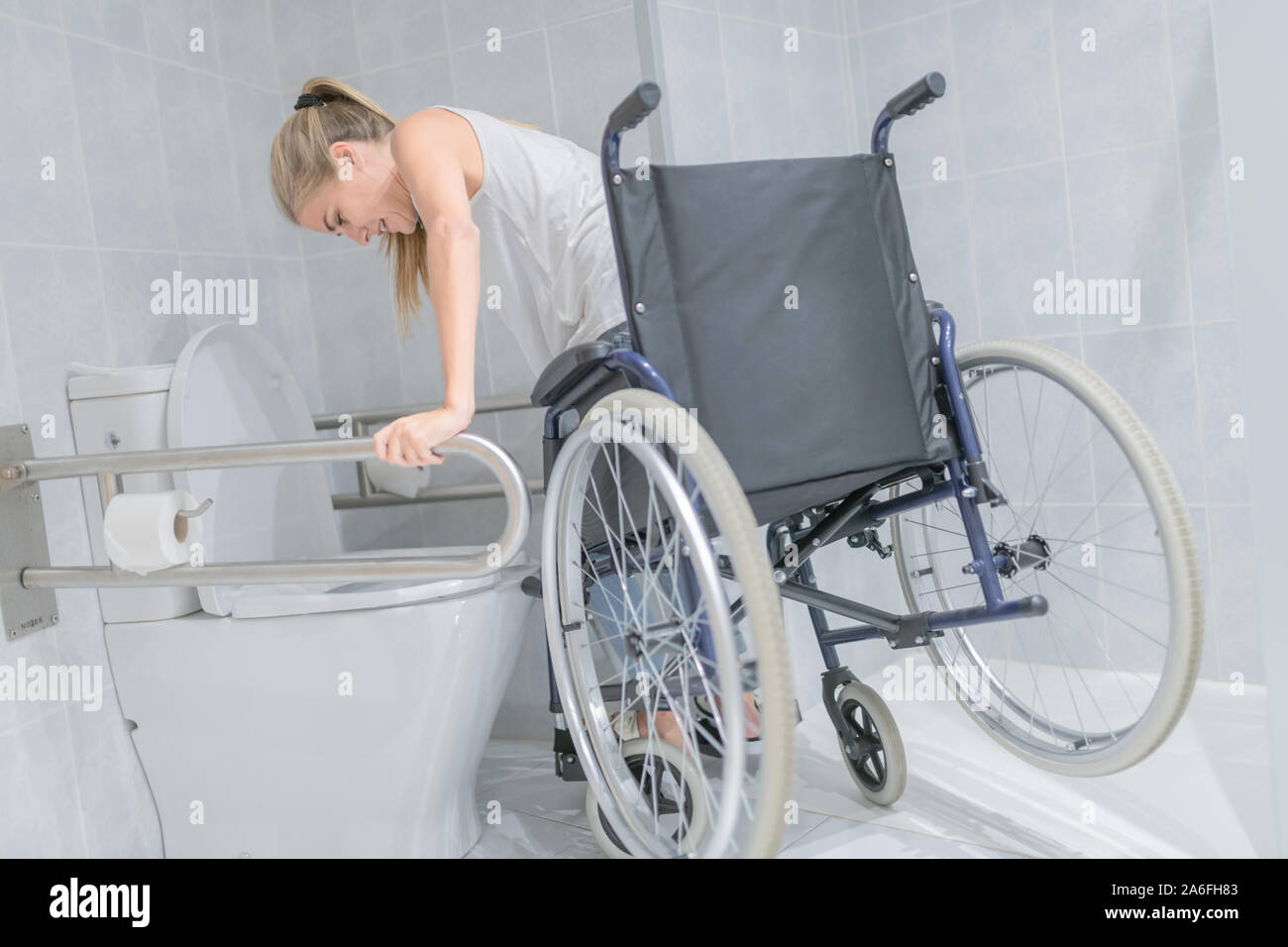 Wheelchair woman moving from chair to bathroom to meet her needs ...