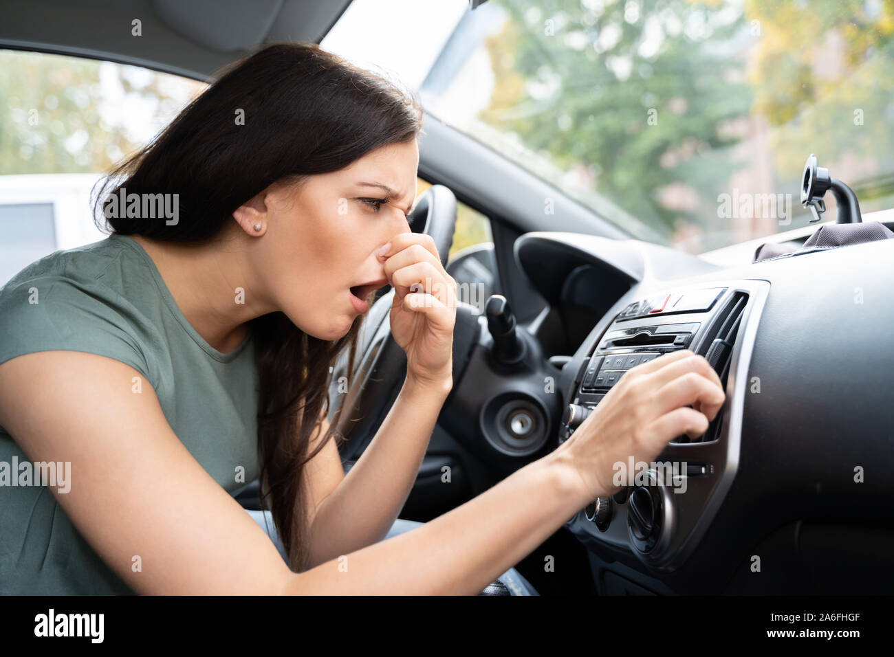 Woman Covering Her Nose From Bad Smell Inside The Car Stock Photo - Alamy