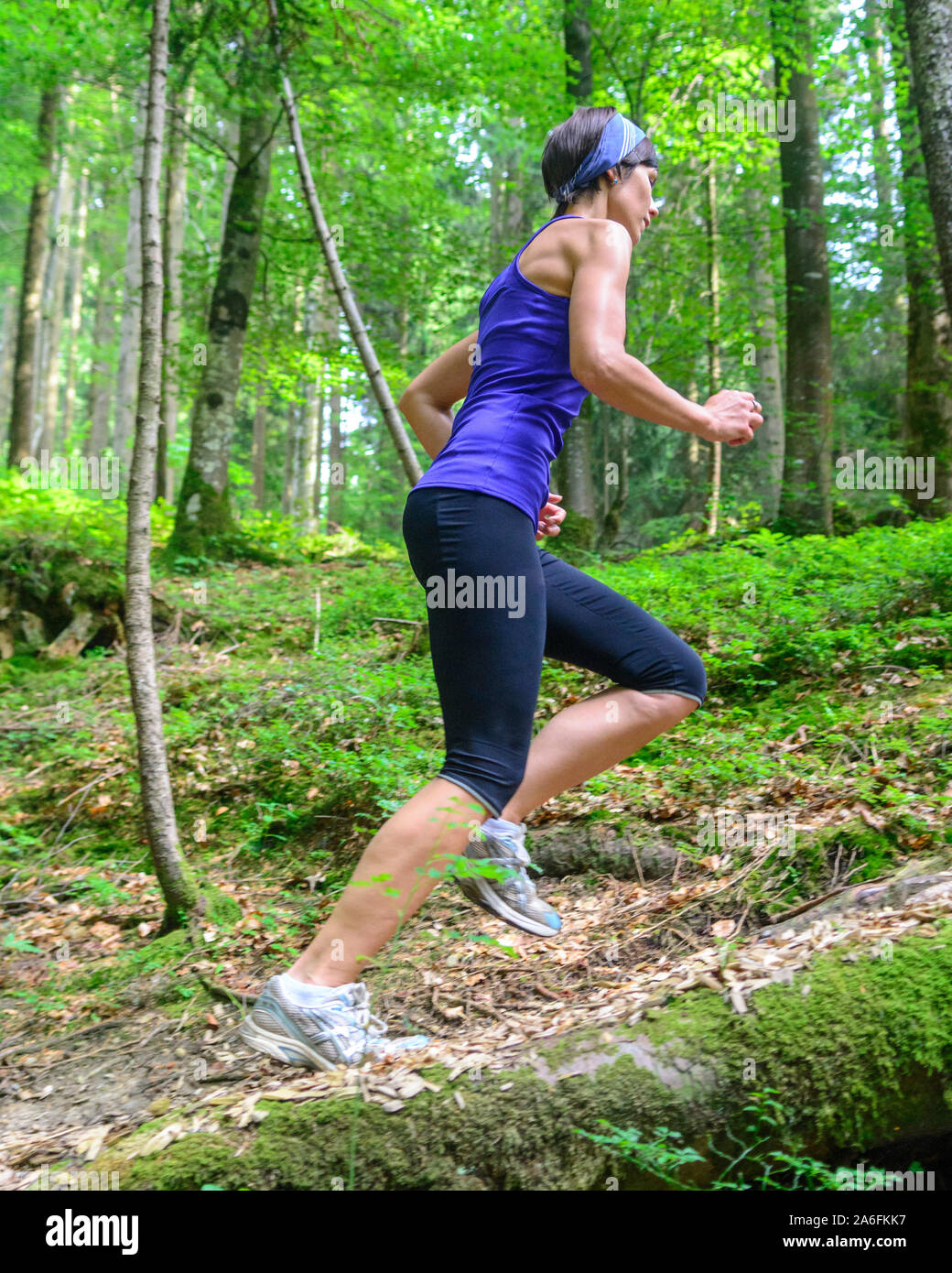 Young person jogging in forest - strenuous workout in summertime Stock ...