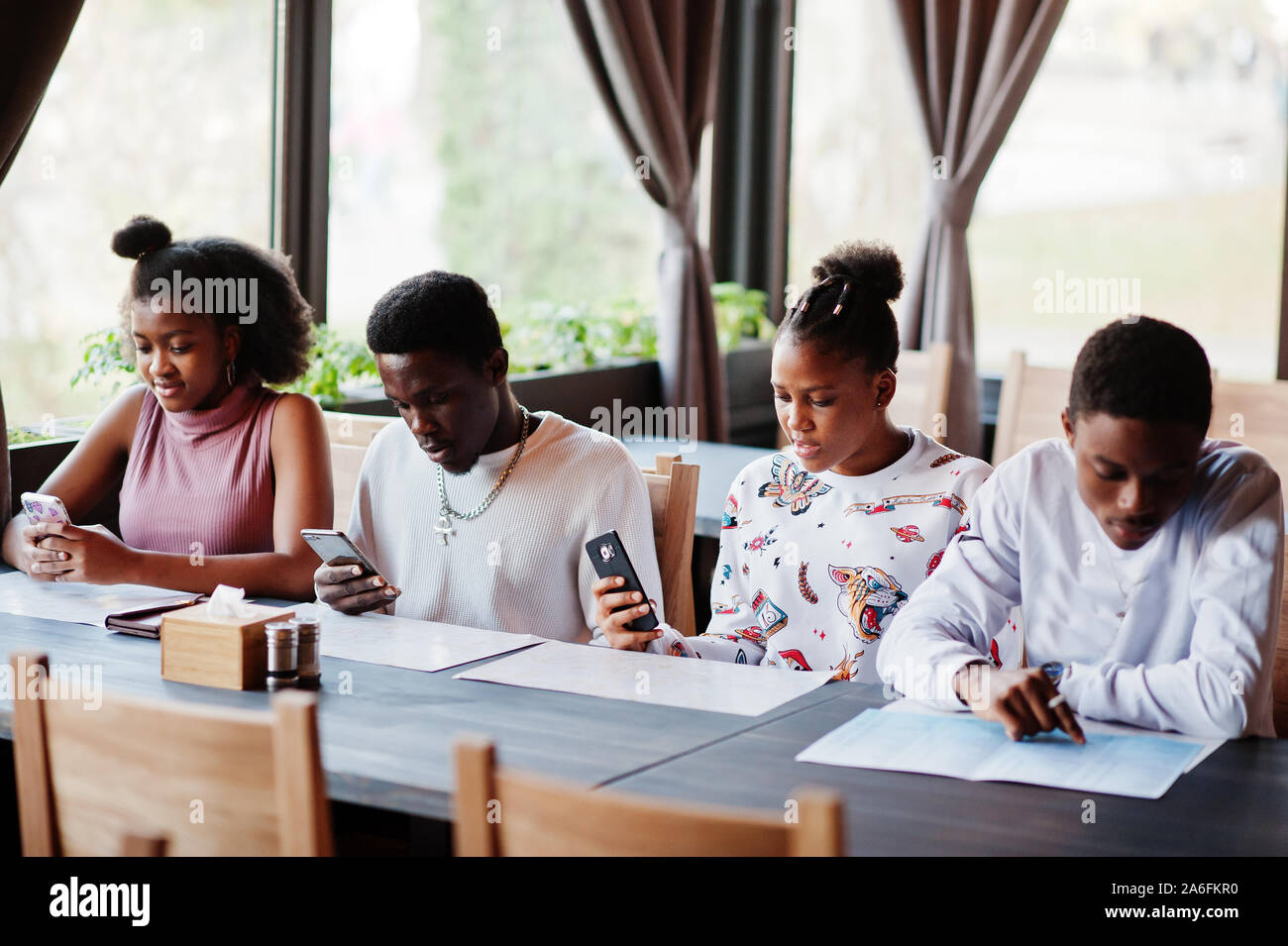 Happy african friends sitting and chatting in cafe. Group of black ...