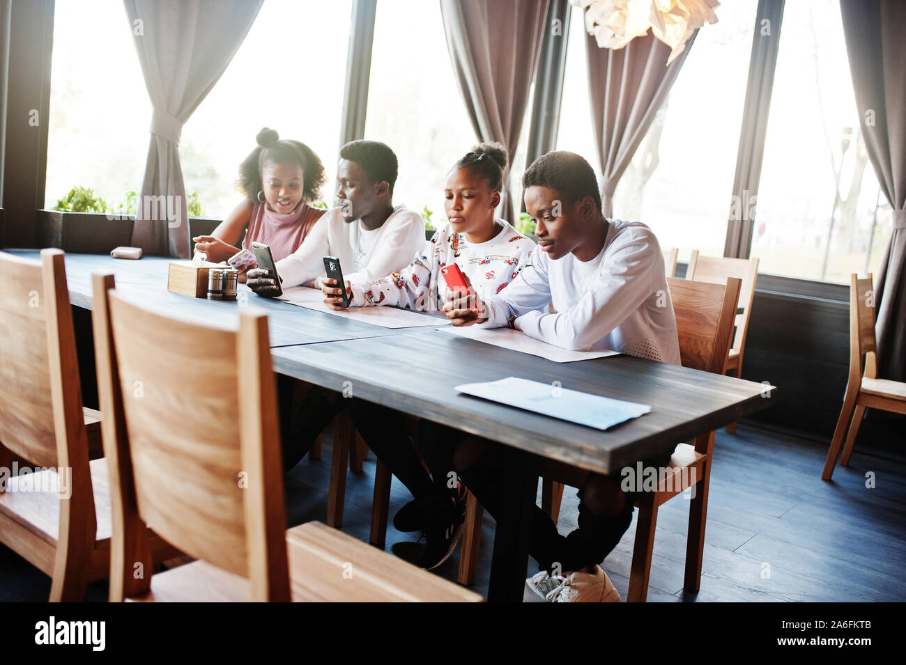 Happy african friends sitting and chatting in cafe. Group of black ...