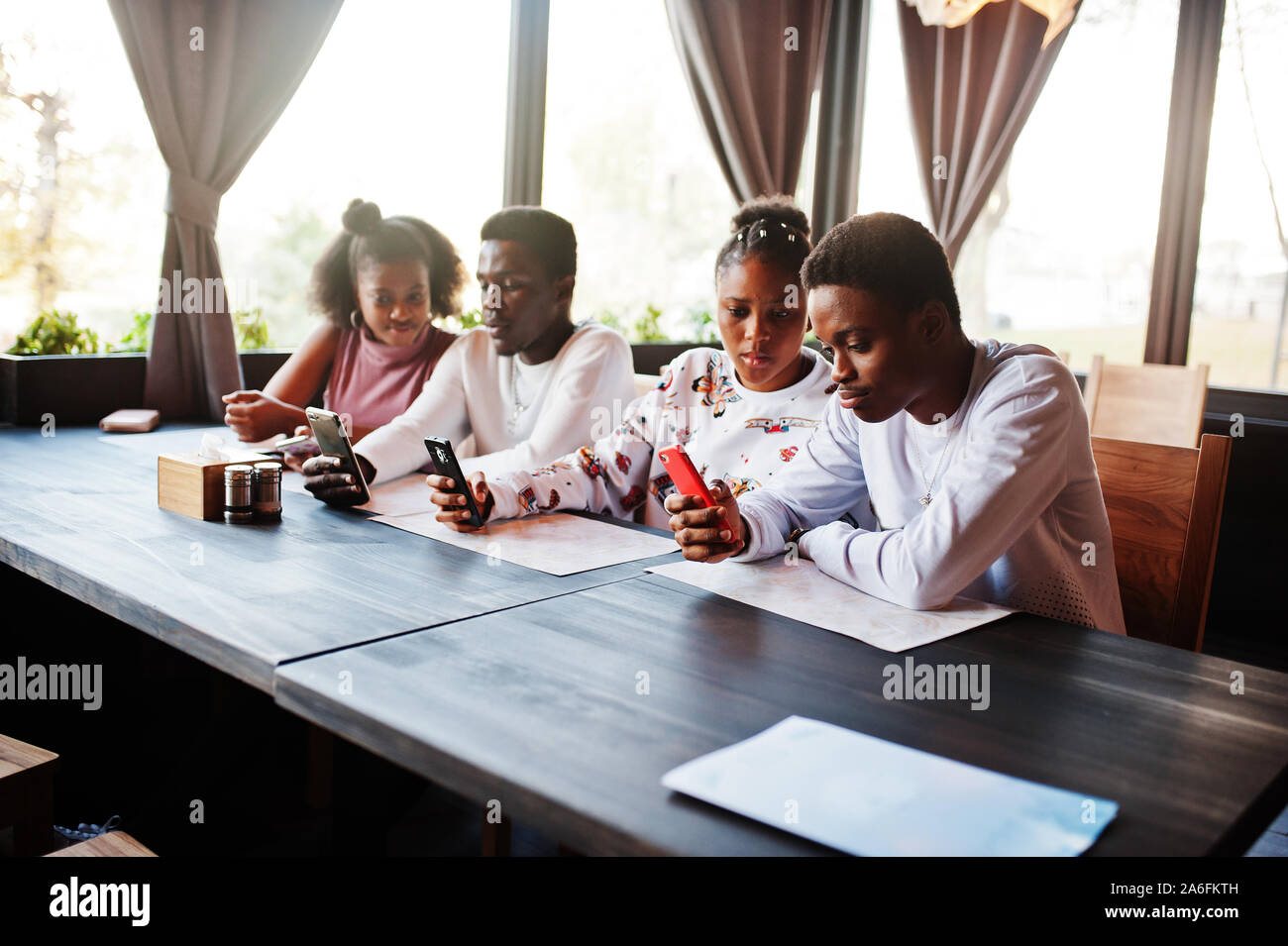 Happy african friends sitting and chatting in cafe. Group of black ...