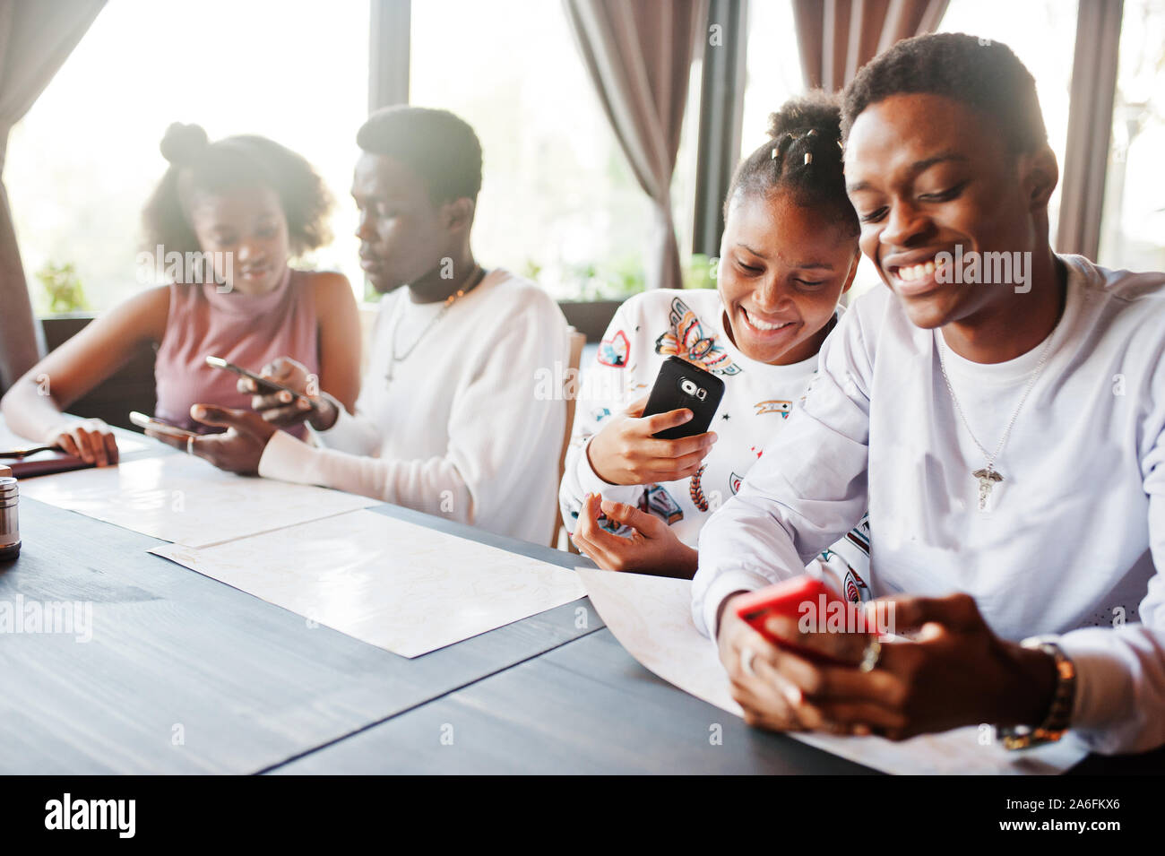 Happy african friends sitting and chatting in cafe. Group of black ...
