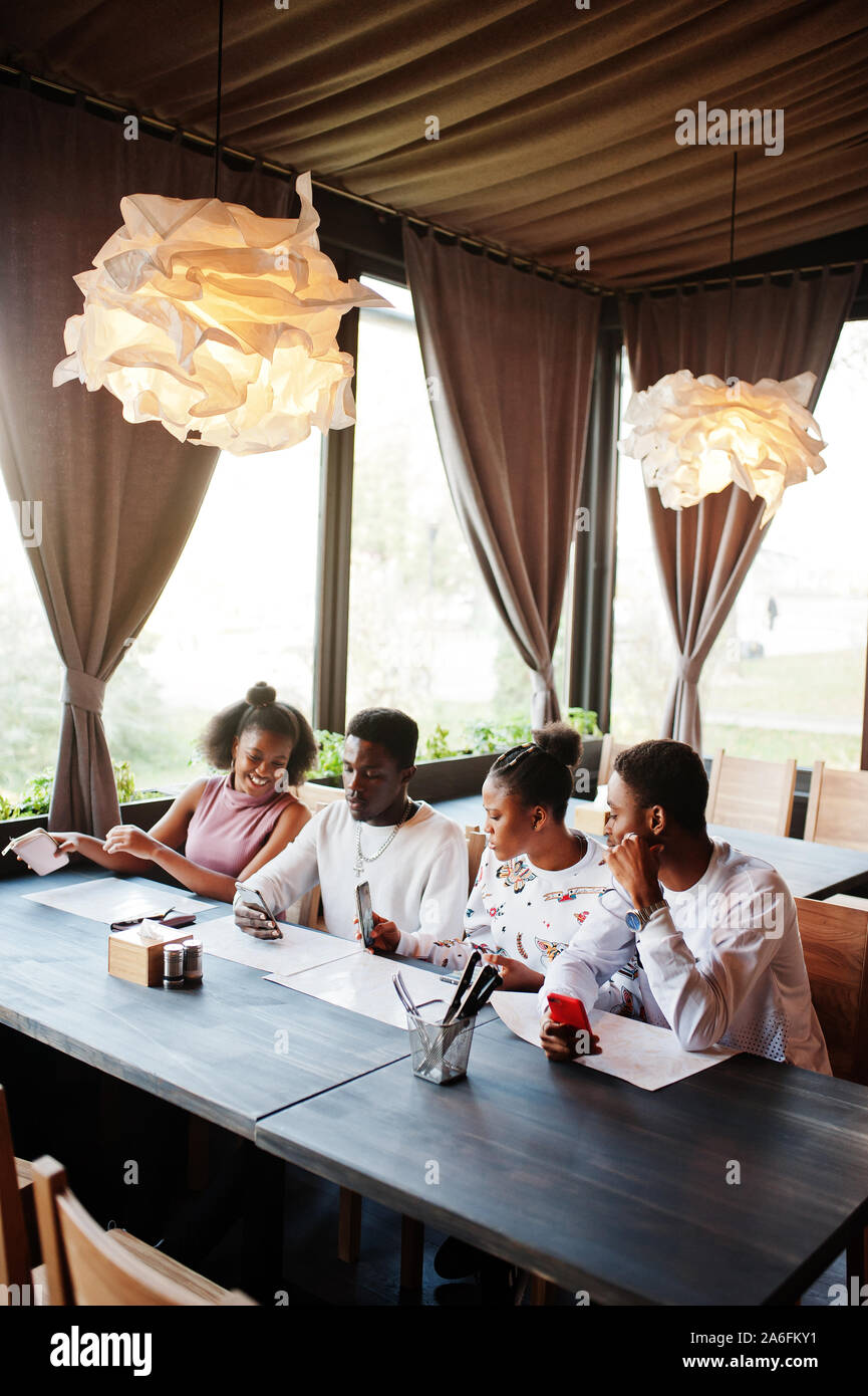 Happy african friends sitting and chatting in cafe. Group of black ...