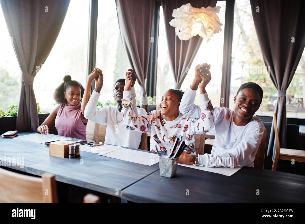 Happy african friends sitting and chatting in cafe. Group of black ...