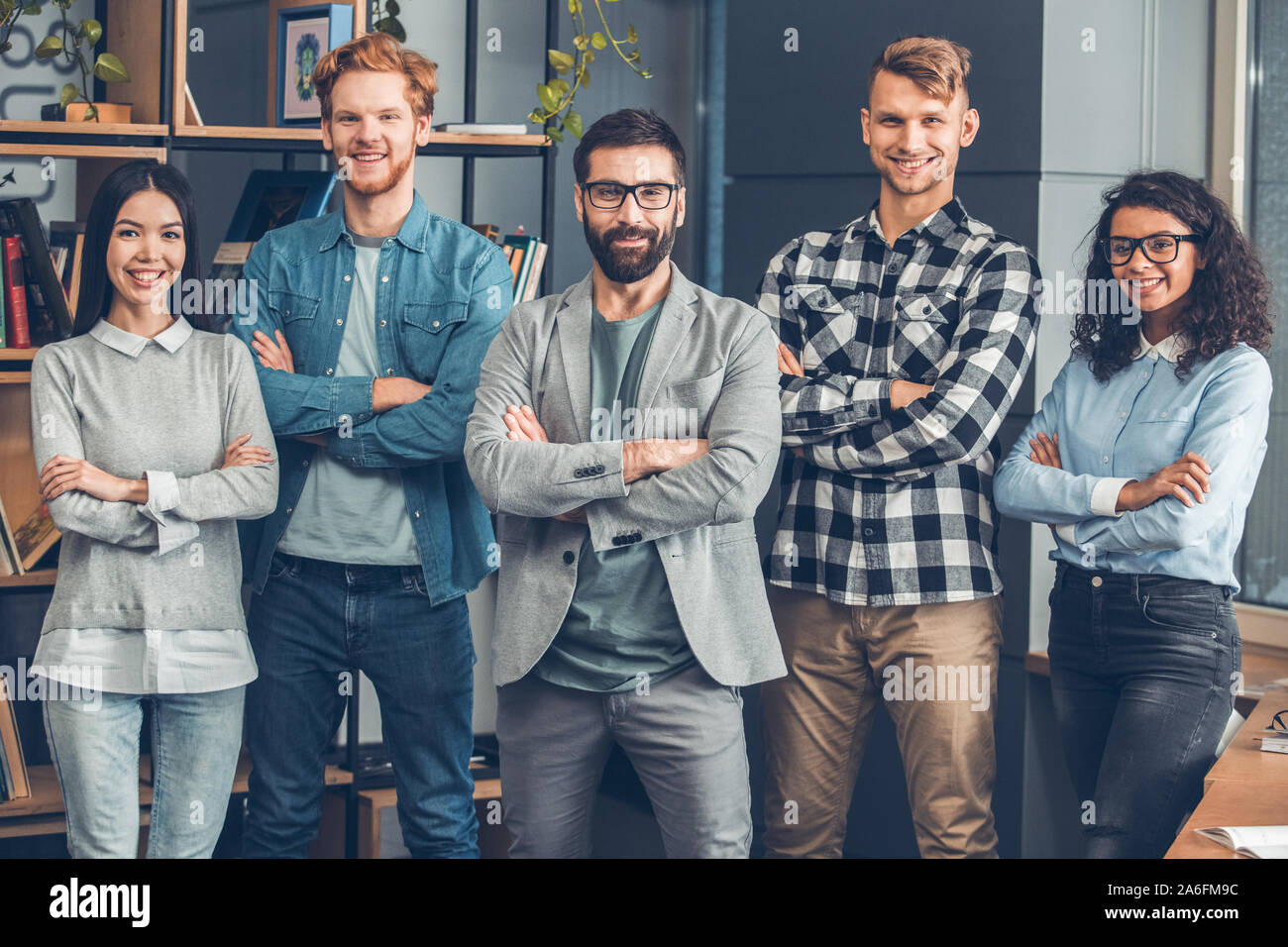Startupers working together at office standing crossed arms looking ...