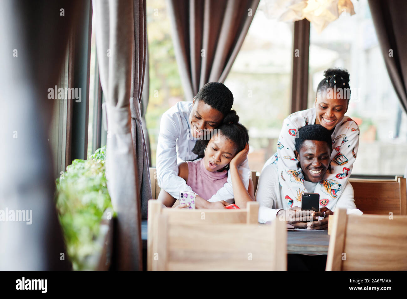 Happy african friends sitting and chatting in cafe. Group of black ...