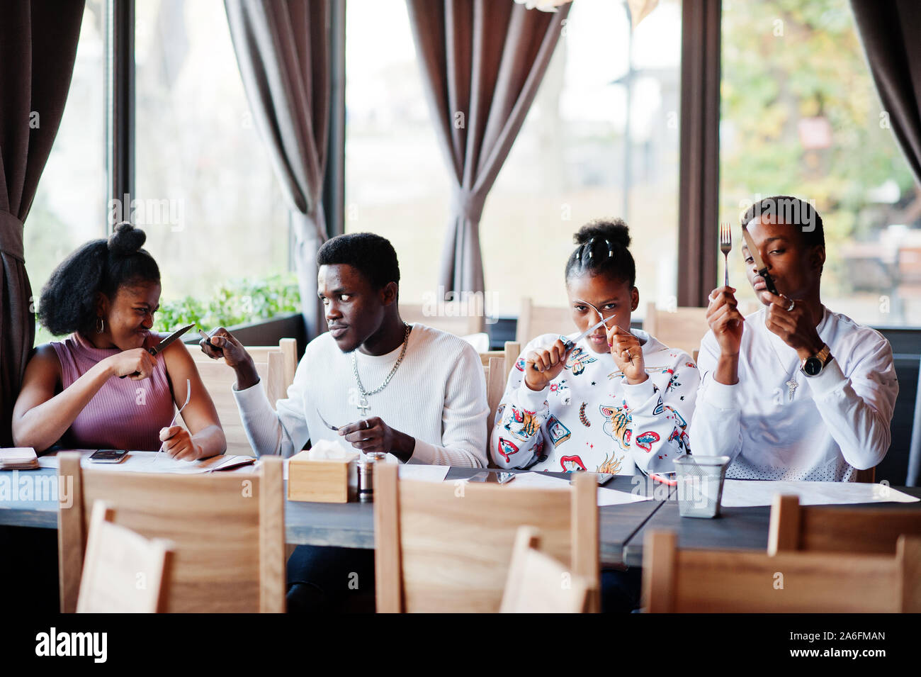 Happy african friends sitting and chatting in cafe. Group of black ...