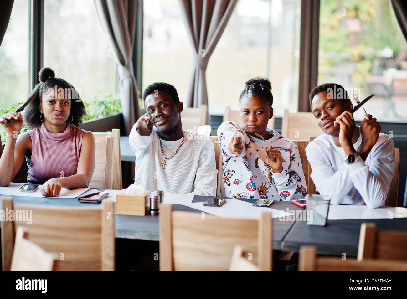 Happy african friends sitting and chatting in cafe. Group of black ...