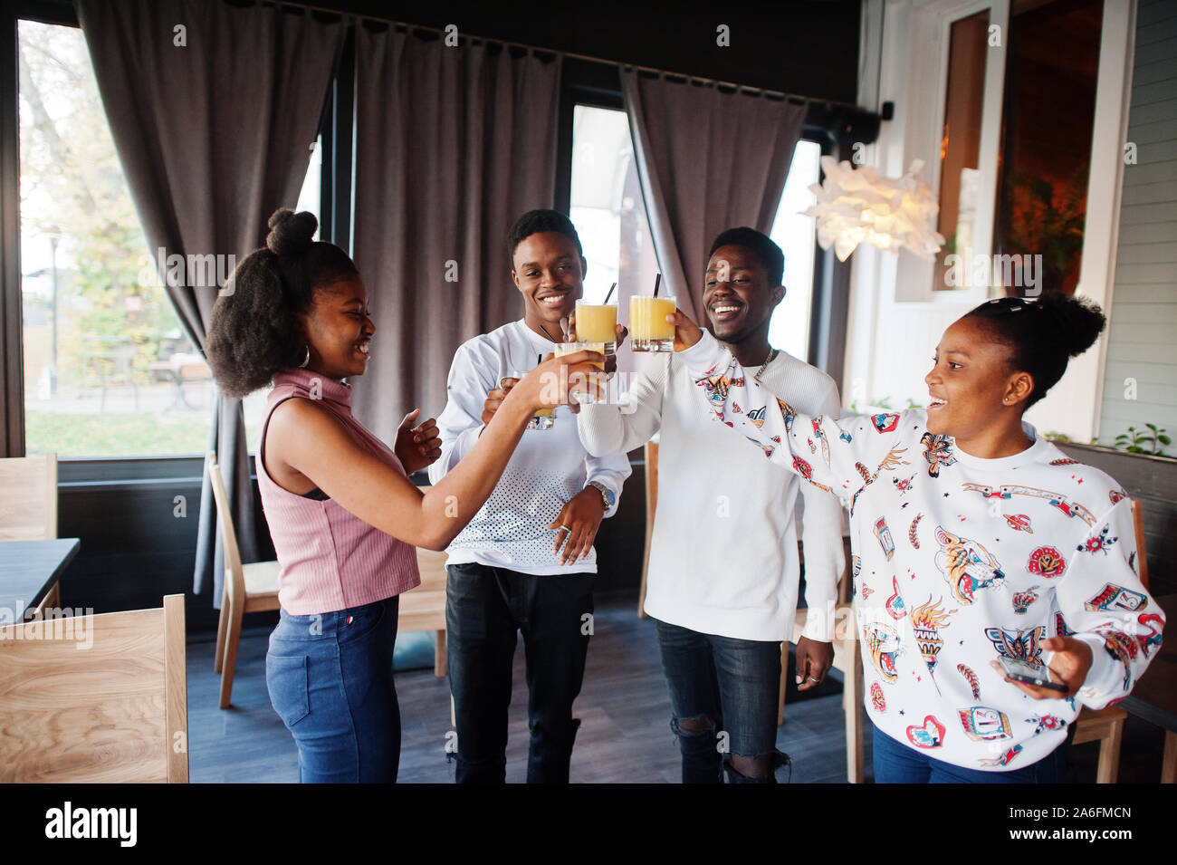 Happy african friends sitting and chatting in cafe. Group of black ...