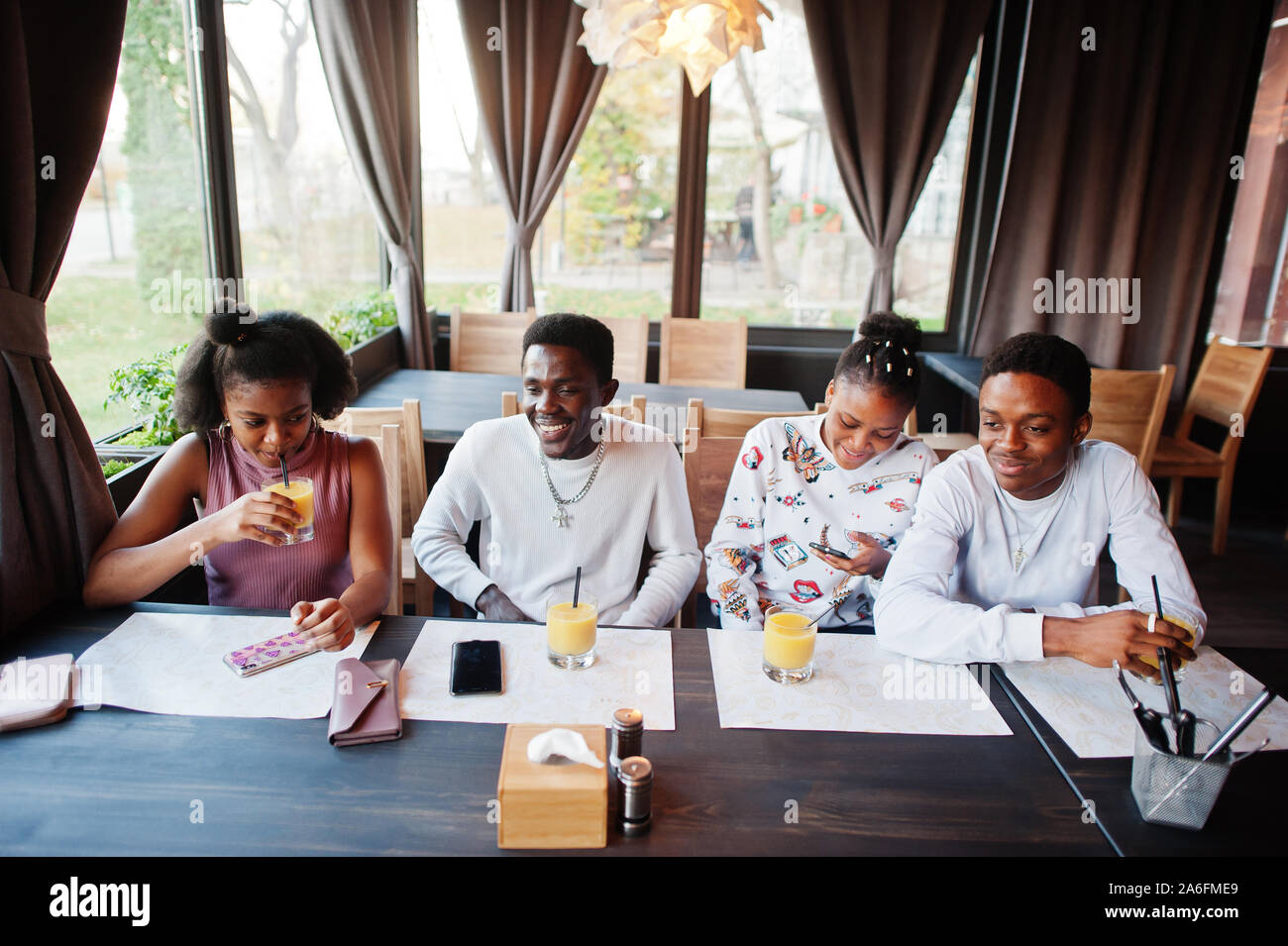 Happy african friends sitting and chatting in cafe. Group of black ...
