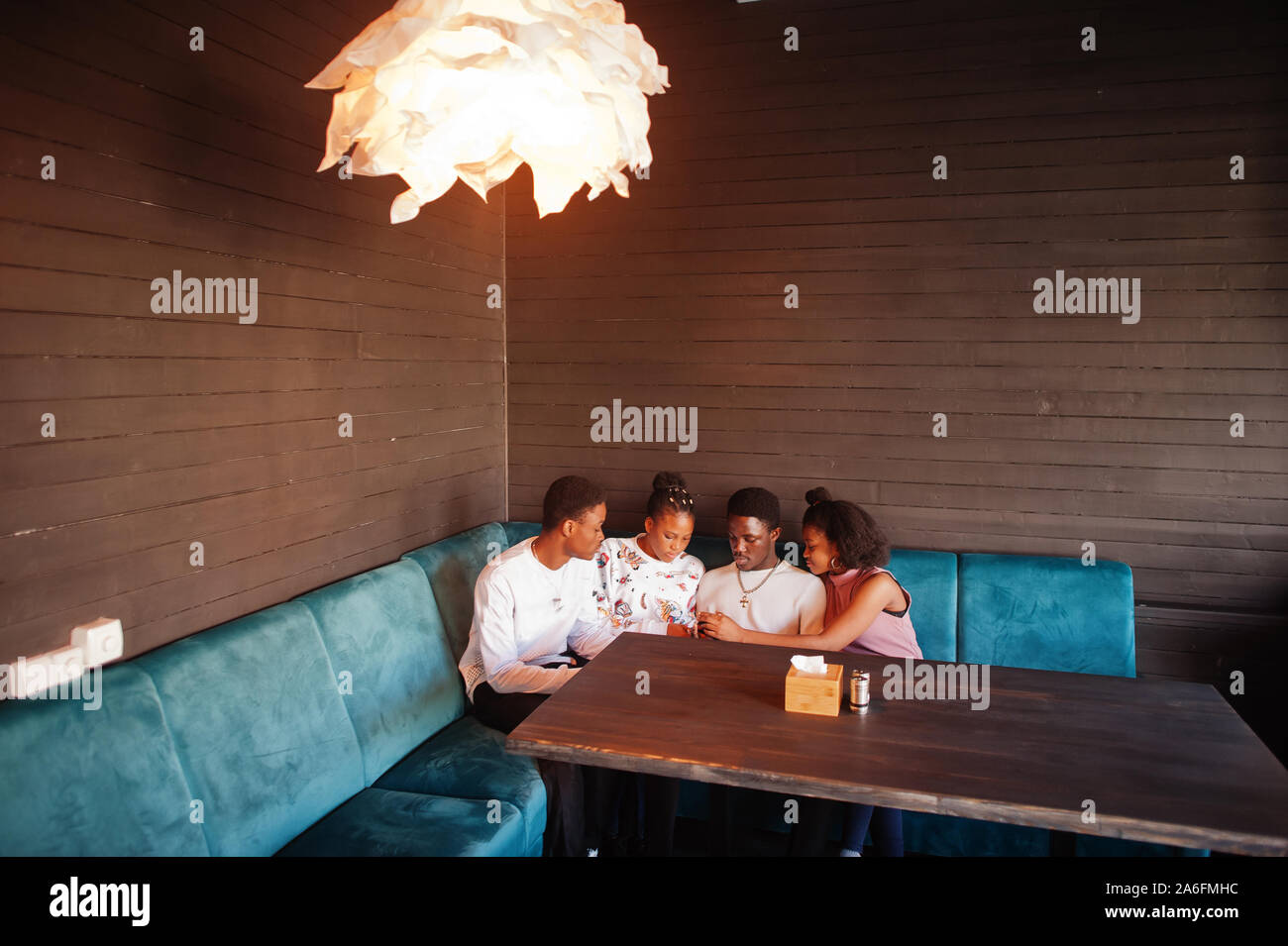 Happy african friends sitting and chatting in cafe. Group of black ...