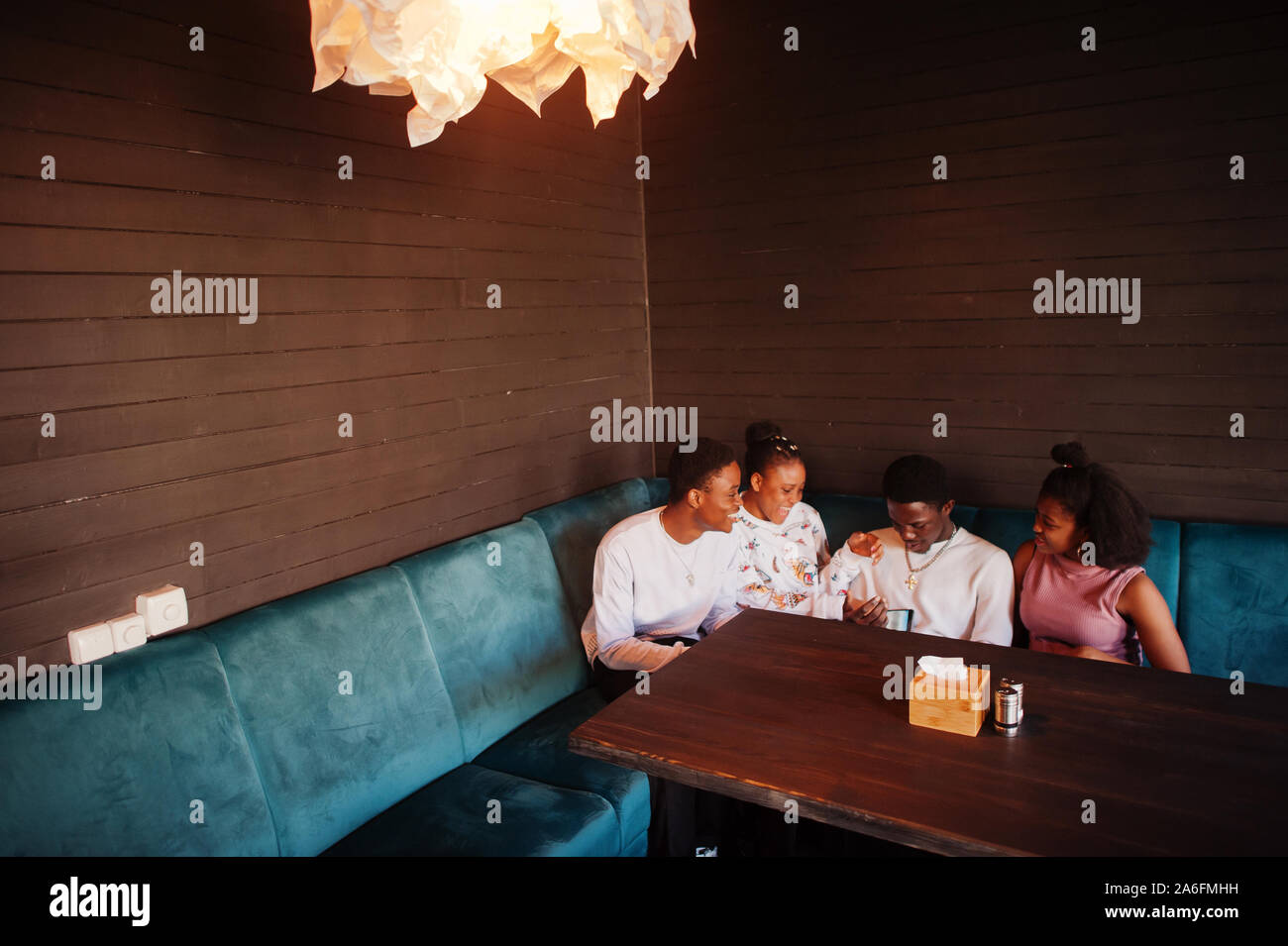 Happy african friends sitting and chatting in cafe. Group of black ...