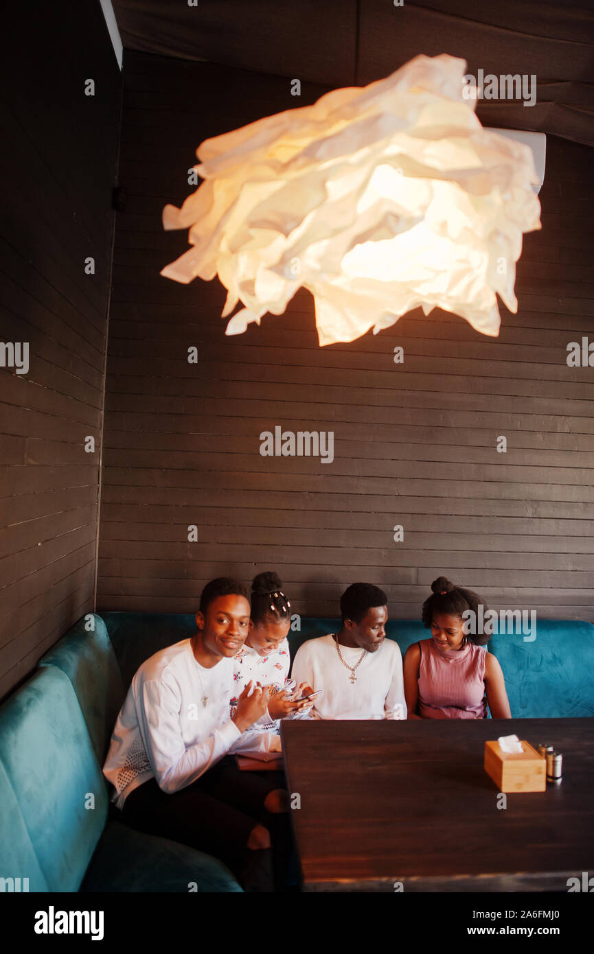 Happy african friends sitting and chatting in cafe. Group of black ...