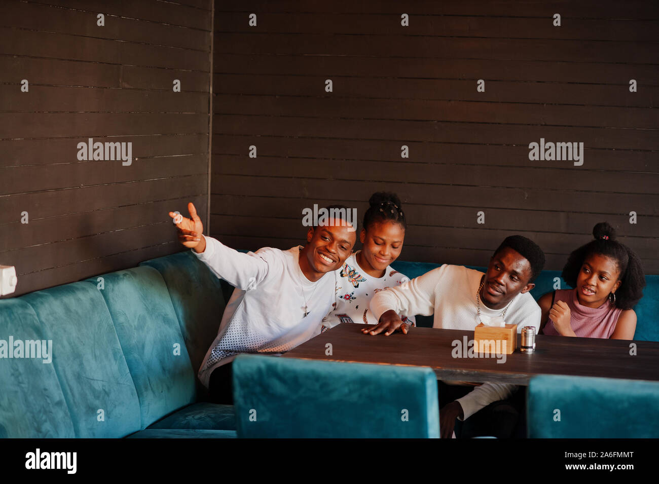 Happy african friends sitting and chatting in cafe. Group of black ...