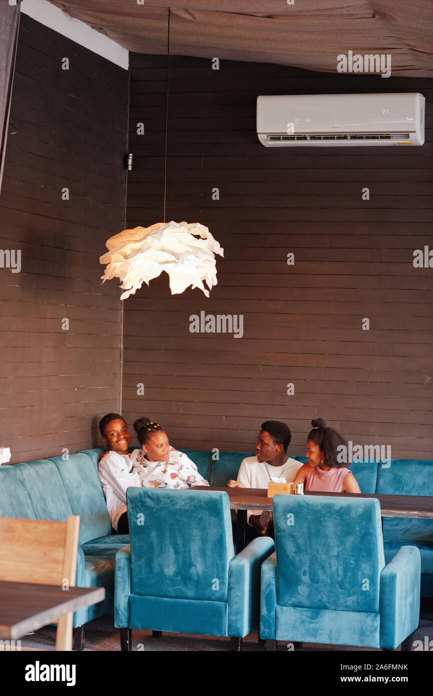 Happy african friends sitting and chatting in cafe. Group of black ...