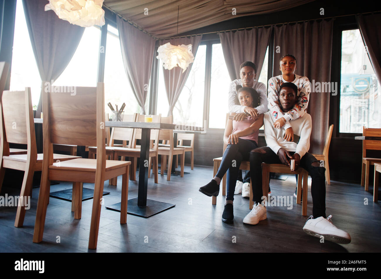 Happy african friends sitting and chatting in cafe. Group of black ...