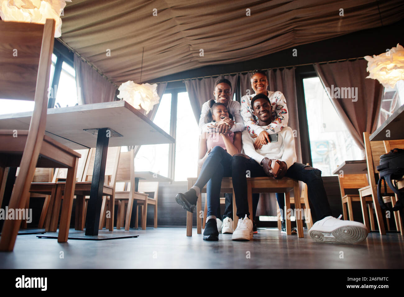 Happy african friends sitting and chatting in cafe. Group of black ...
