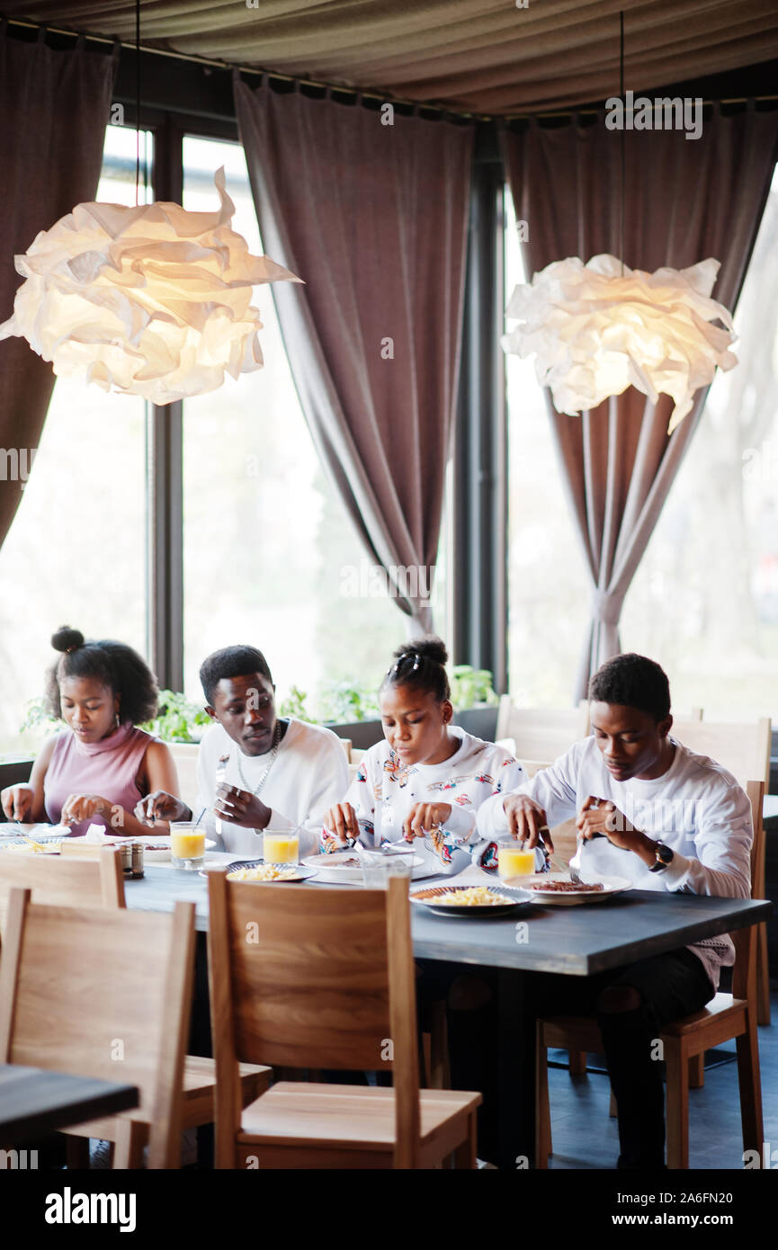 Happy african friends sitting, chatting in cafe and eat food. Group of ...