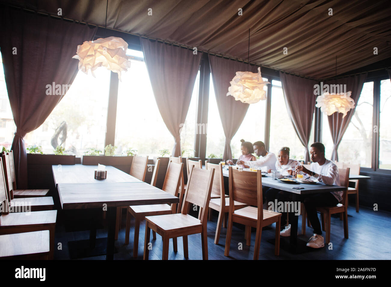 Happy african friends sitting, chatting in cafe and eat food. Group of ...