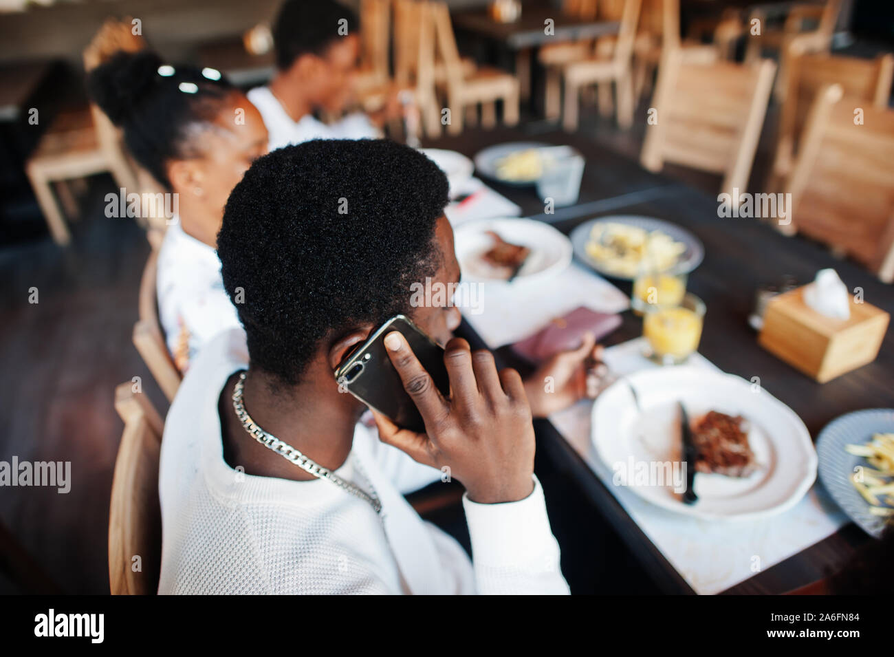 Happy african friends sitting, chatting in cafe and eat food. Group of ...