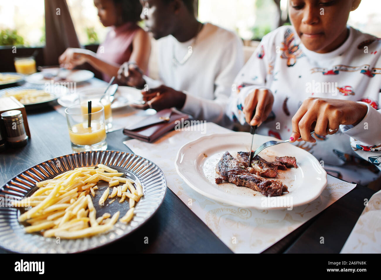 Happy african friends sitting, chatting in cafe and eat food. Group of ...