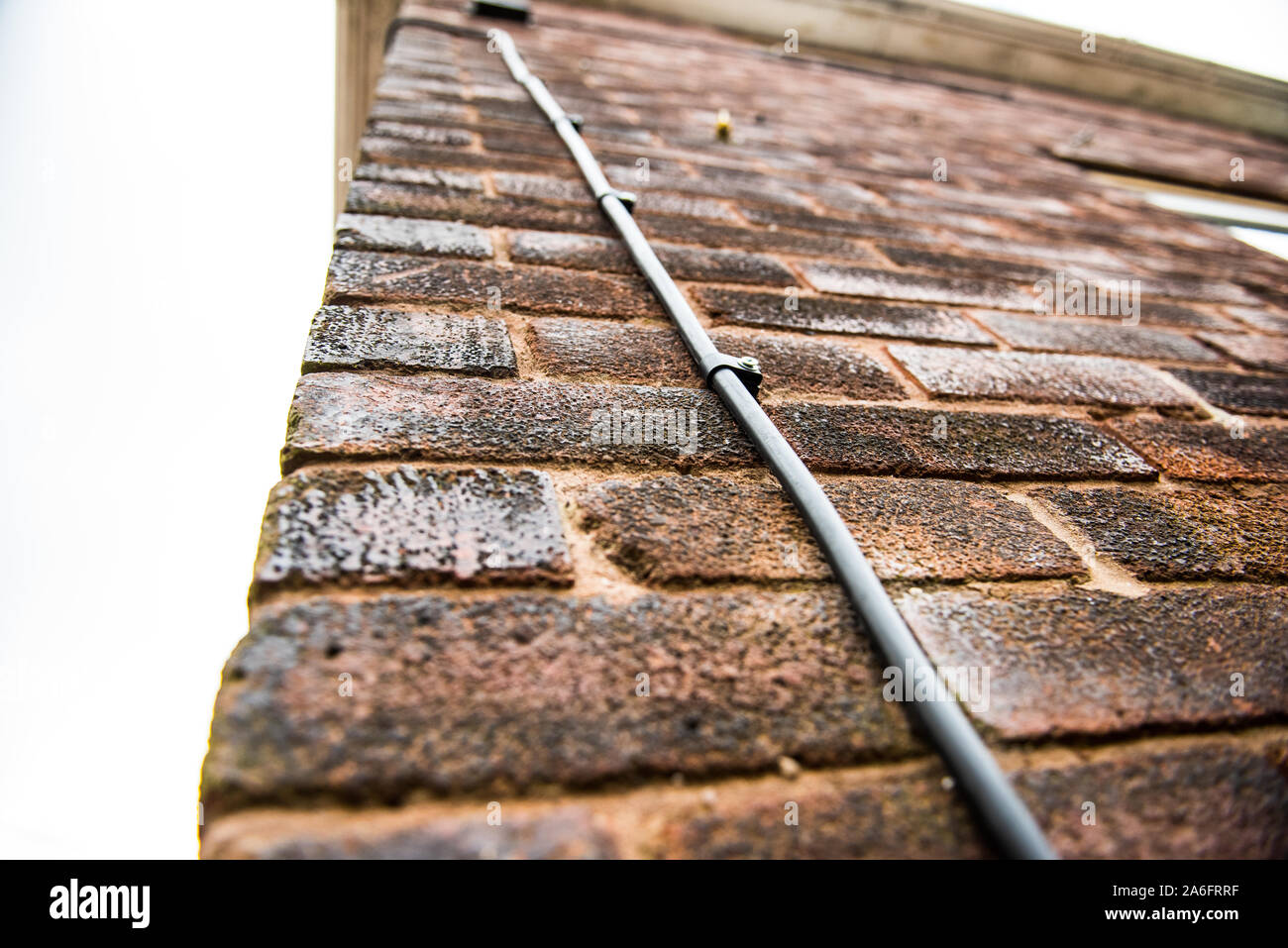 An electrical cable running up the side of a house to an external ...