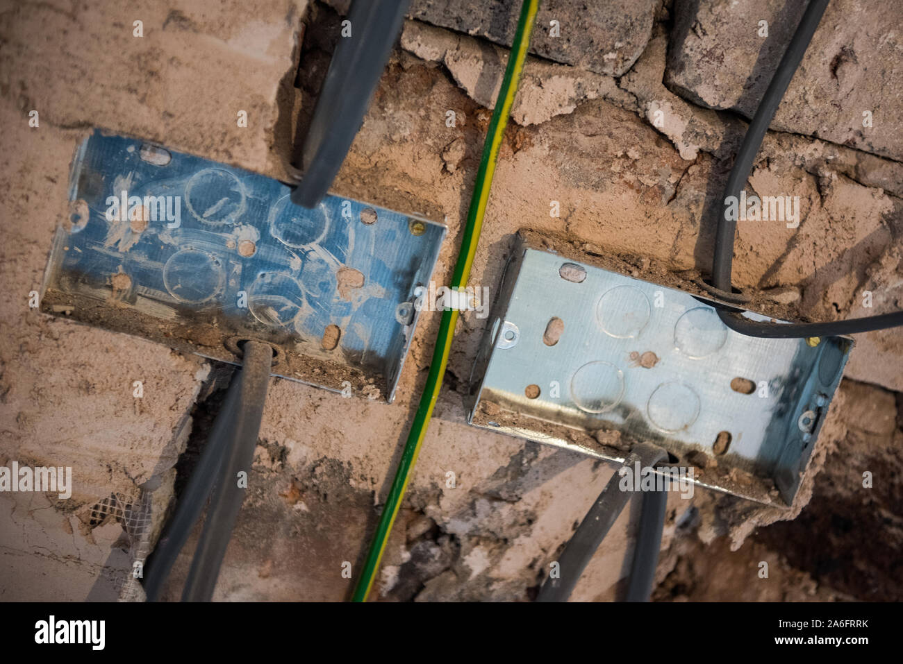 An electrician wires in the 1st fix of an electrical installation ...