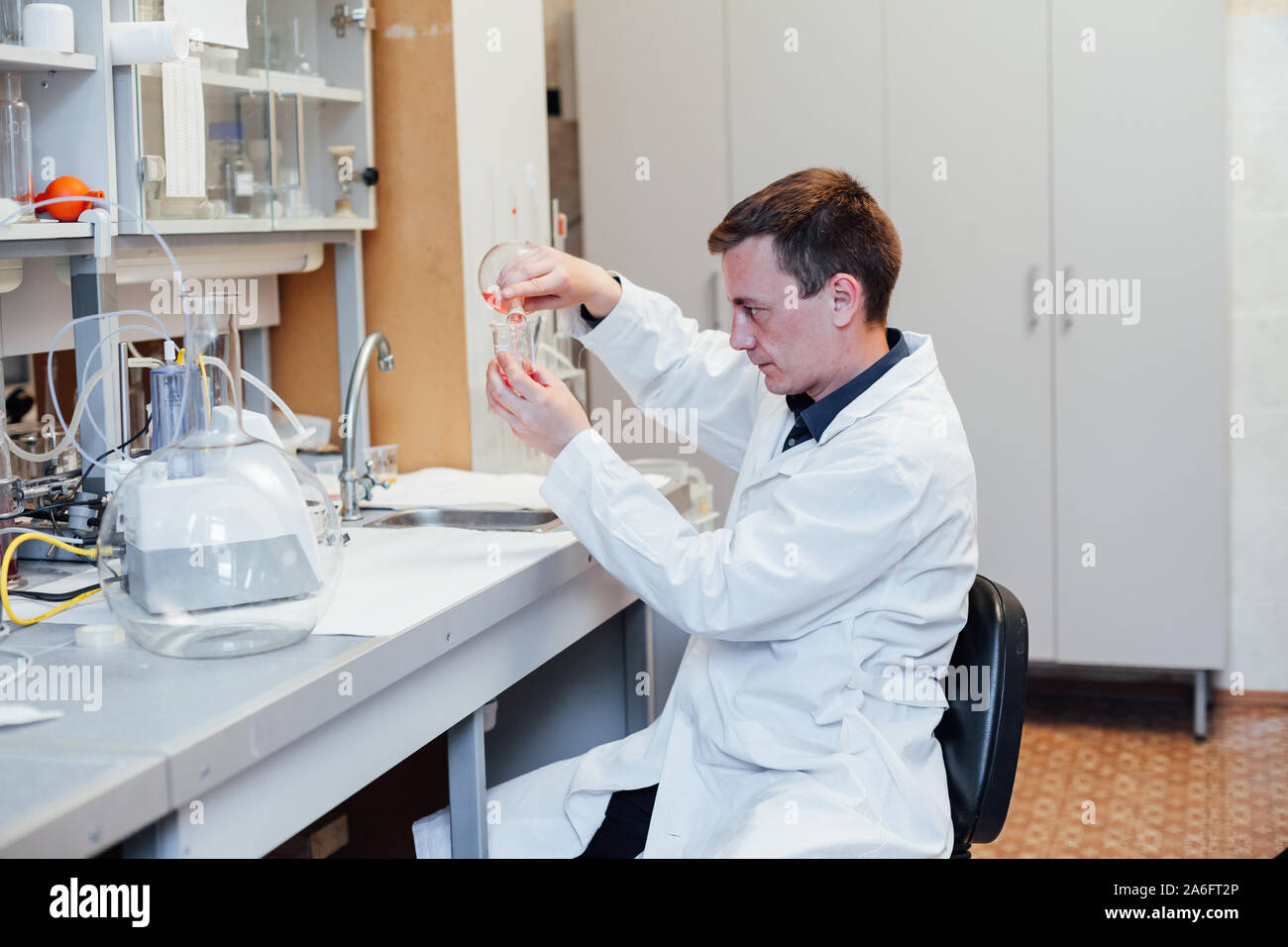 male scientist conducts chemical experiments with liquids in science ...