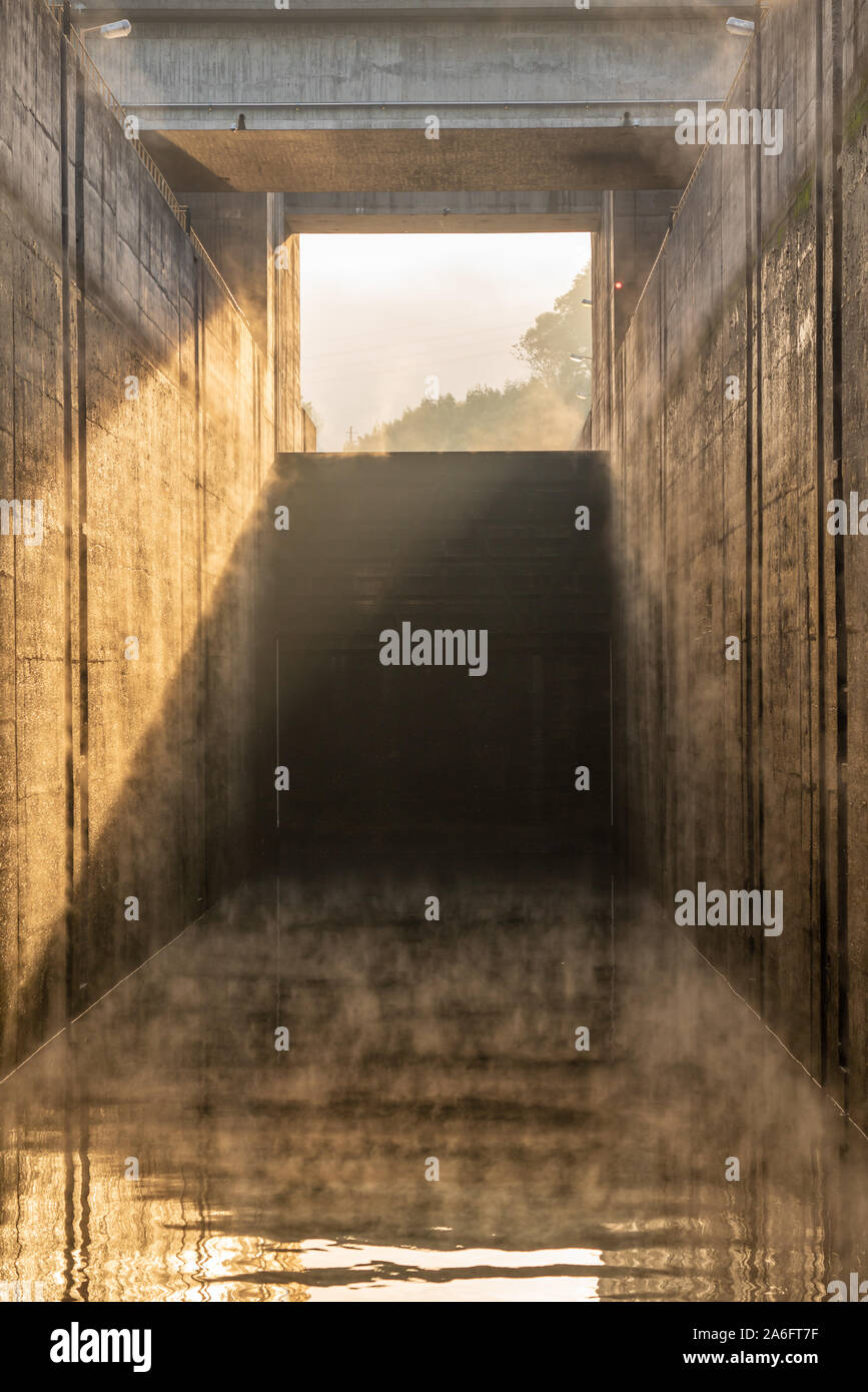 Calm water inside the concrete lock with the mist from sunrise at the ...