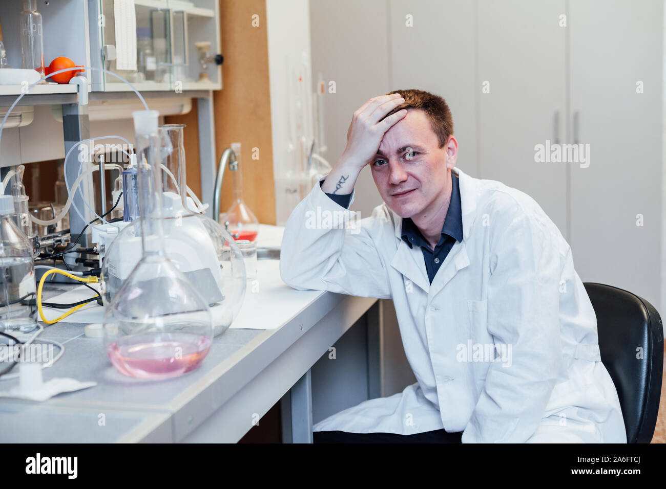 male scientist conducts chemical experiments with liquids in science ...