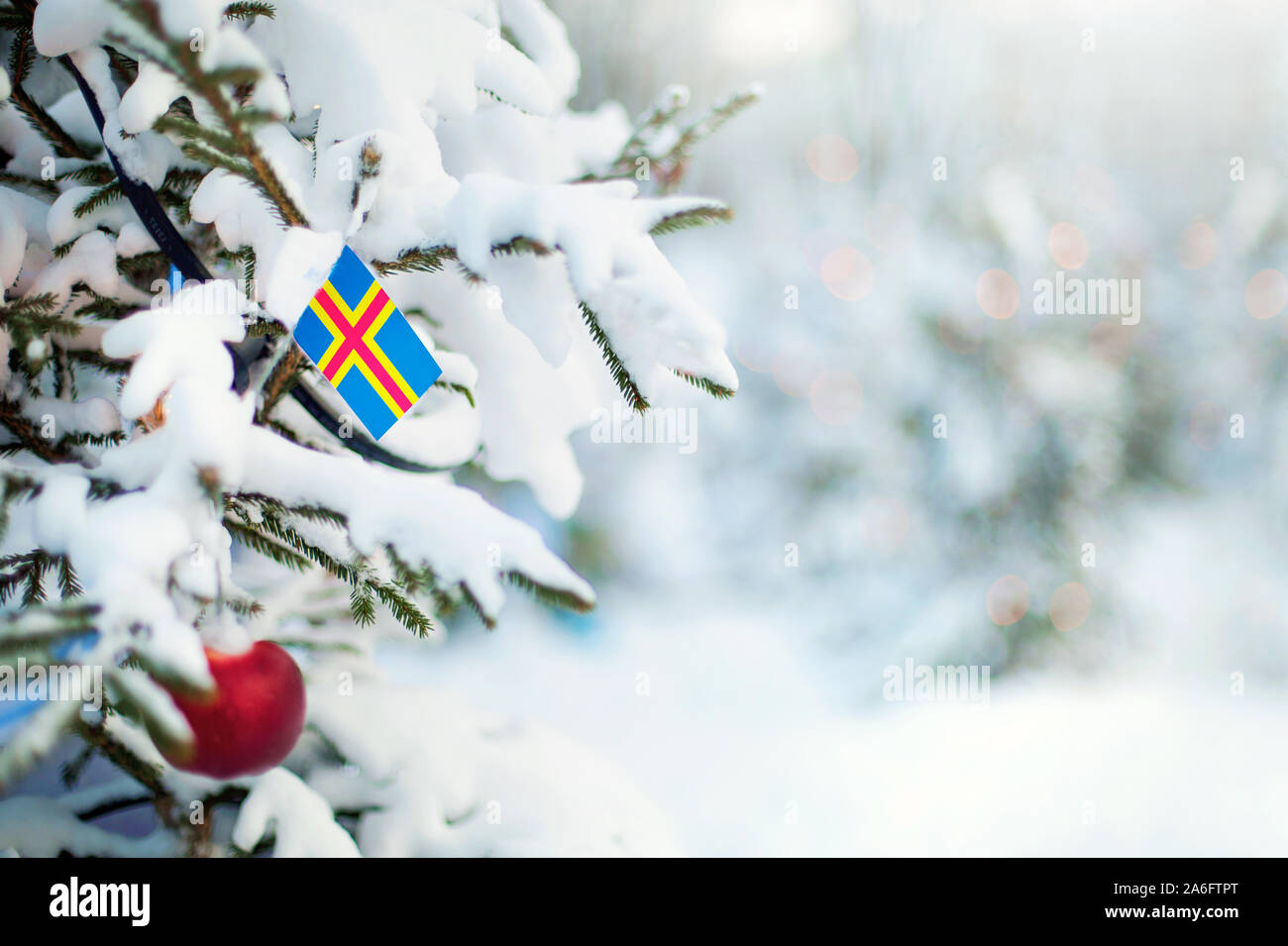 Christmas Aland. Xmas tree covered with snow, decorations and a flag of ...