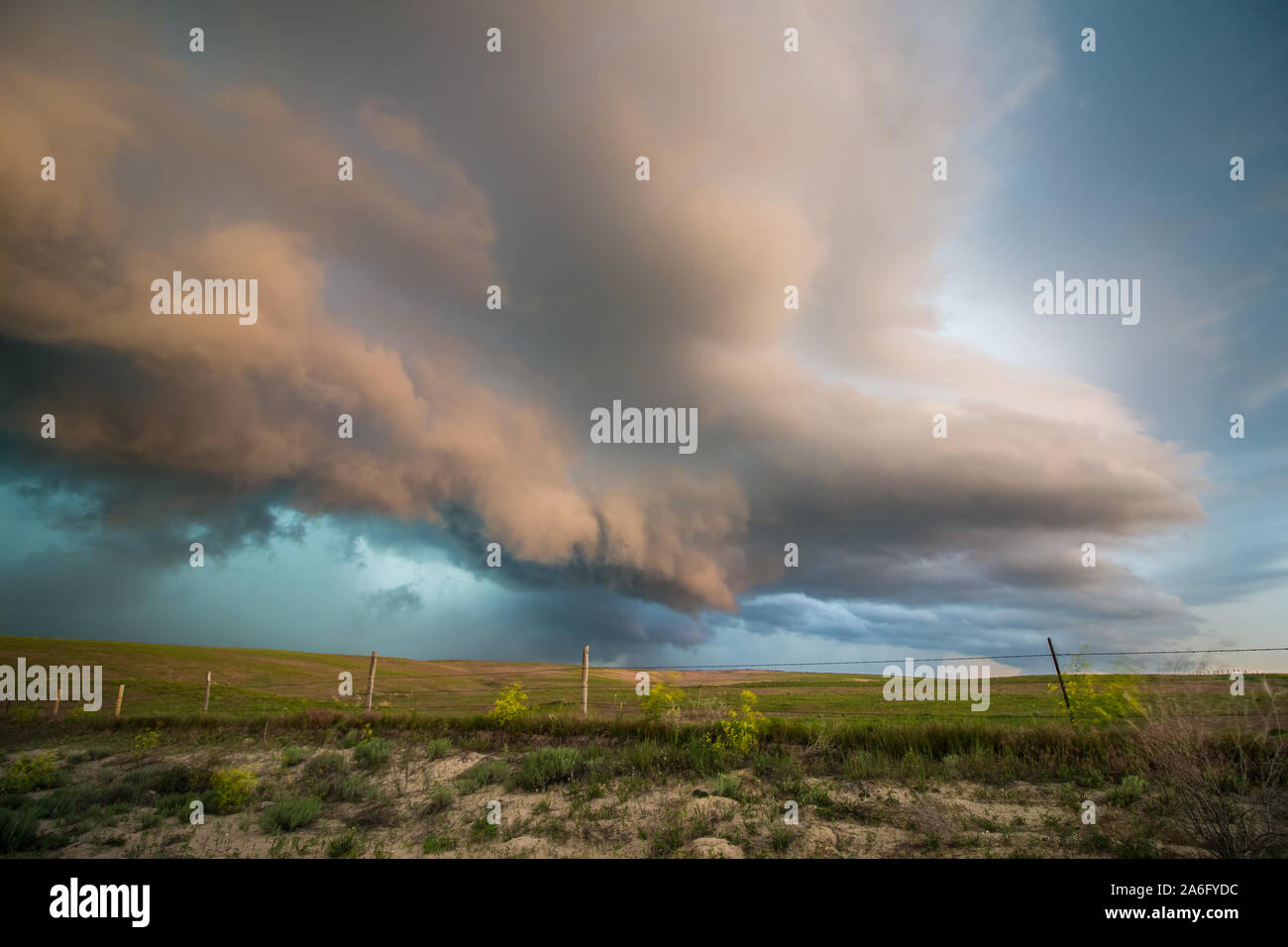 The shelf cloud of a severe storm is lit beautifully by light from the ...