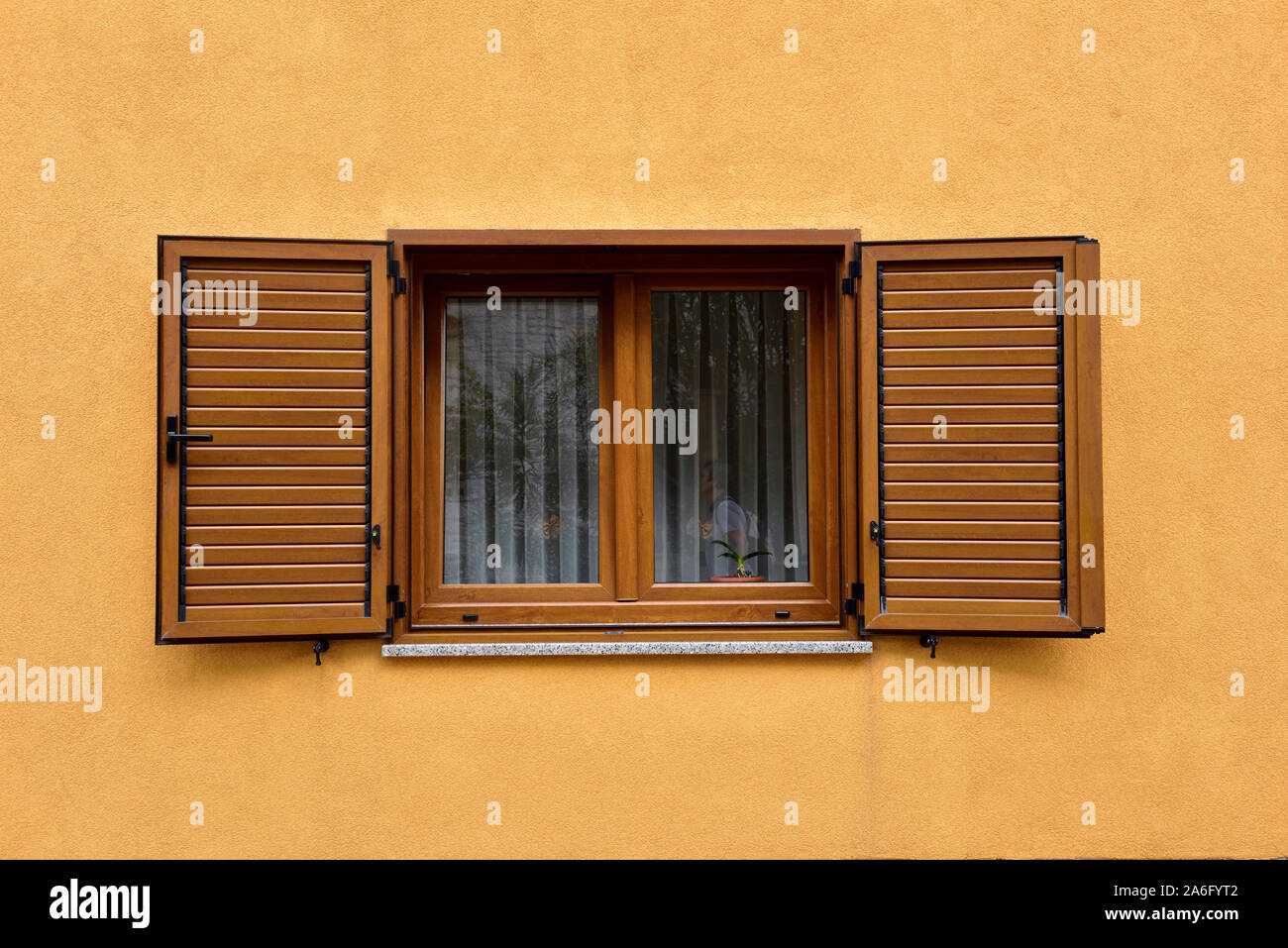 House new modern wooden window with shutters open against plane orange ...