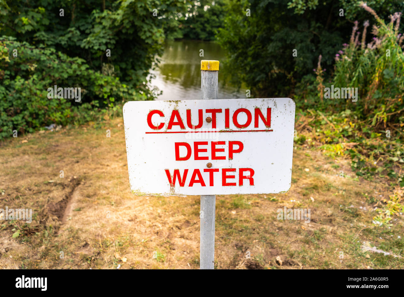 Caution deep water sign, by the side of a large lake, river, hazard ...