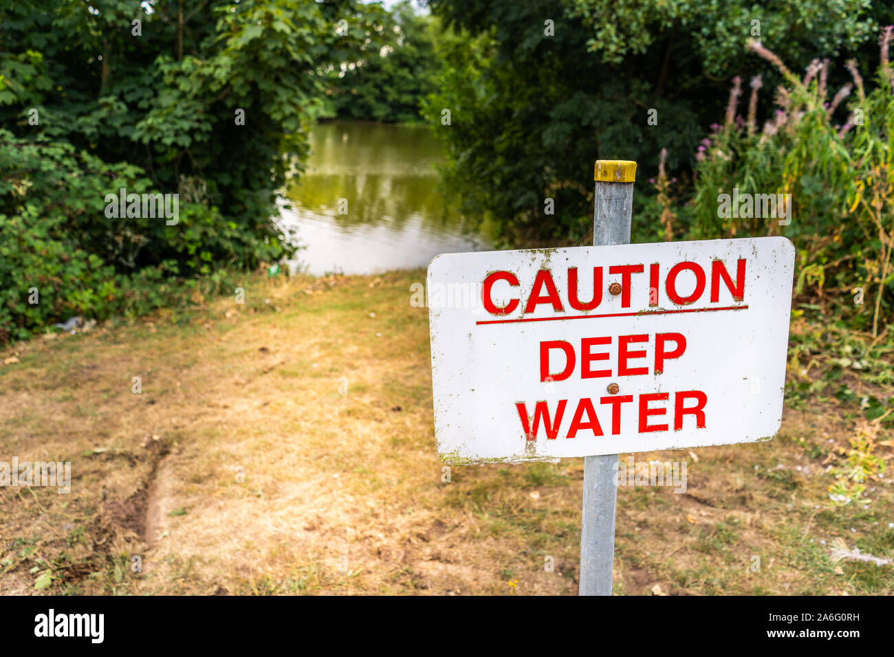 Caution deep water sign, by the side of a large lake, river, hazard ...