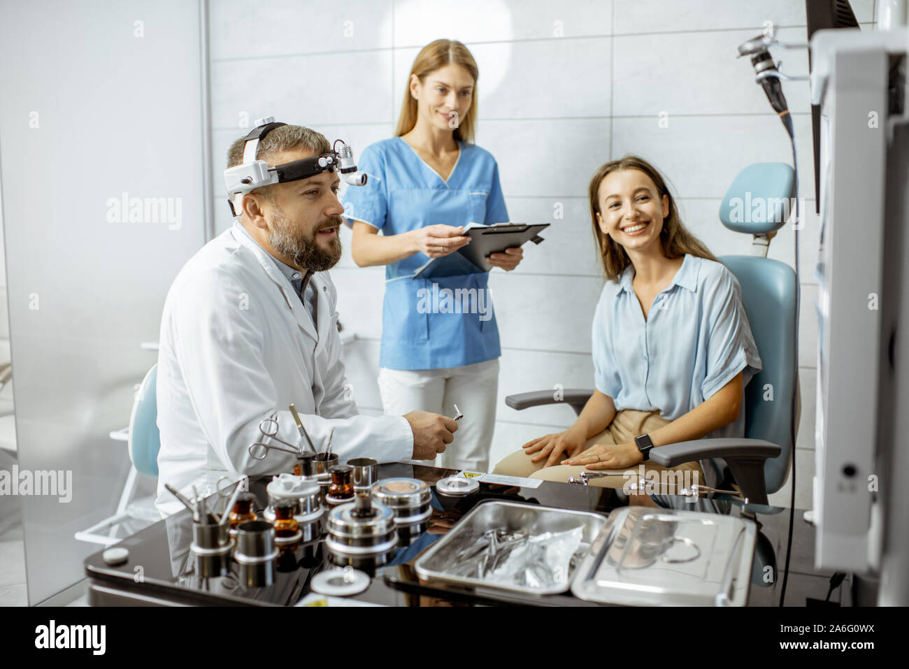 Patient with senior otolaryngologist and female assistant in ENT office ...