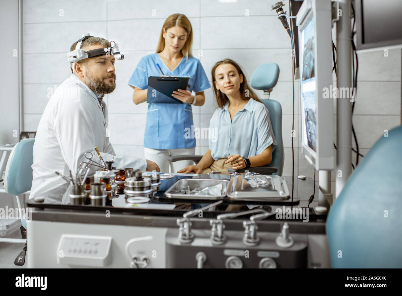 Patient with senior otolaryngologist and female assistant in ENT office ...