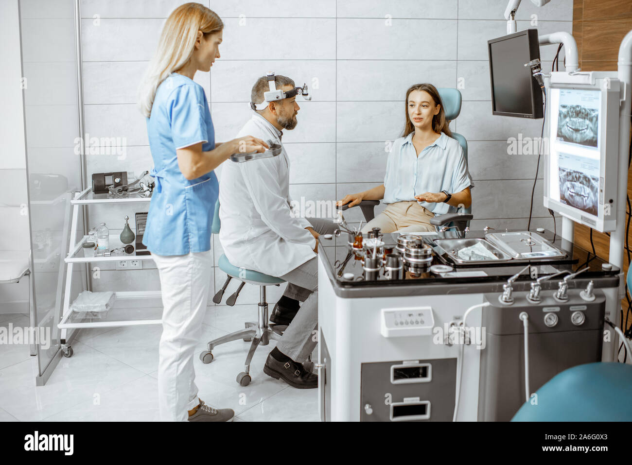 Patient with senior otolaryngologist and female assistant in ENT office ...