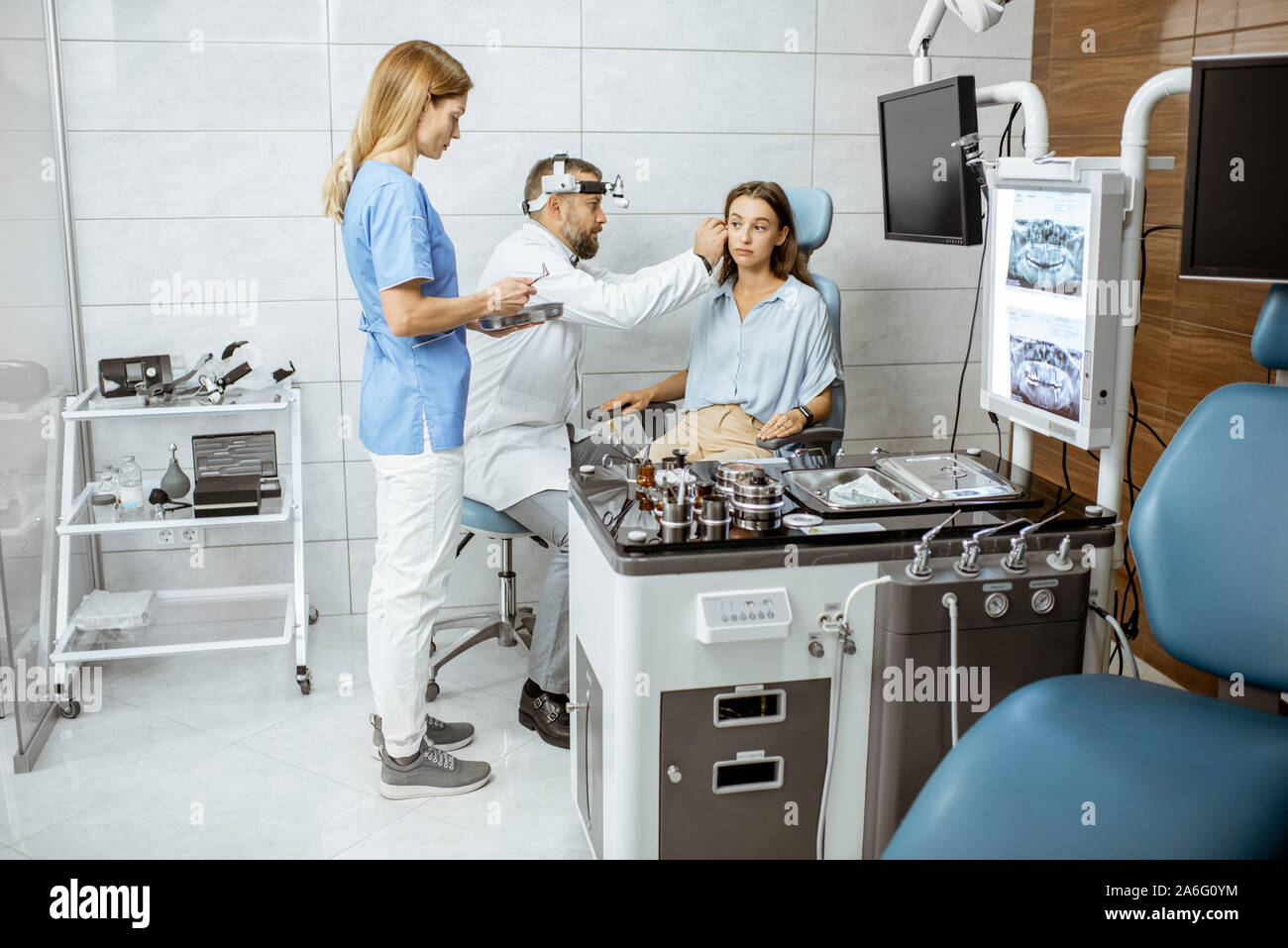 Senior otolaryngologist examining ear of a young patient with female ...
