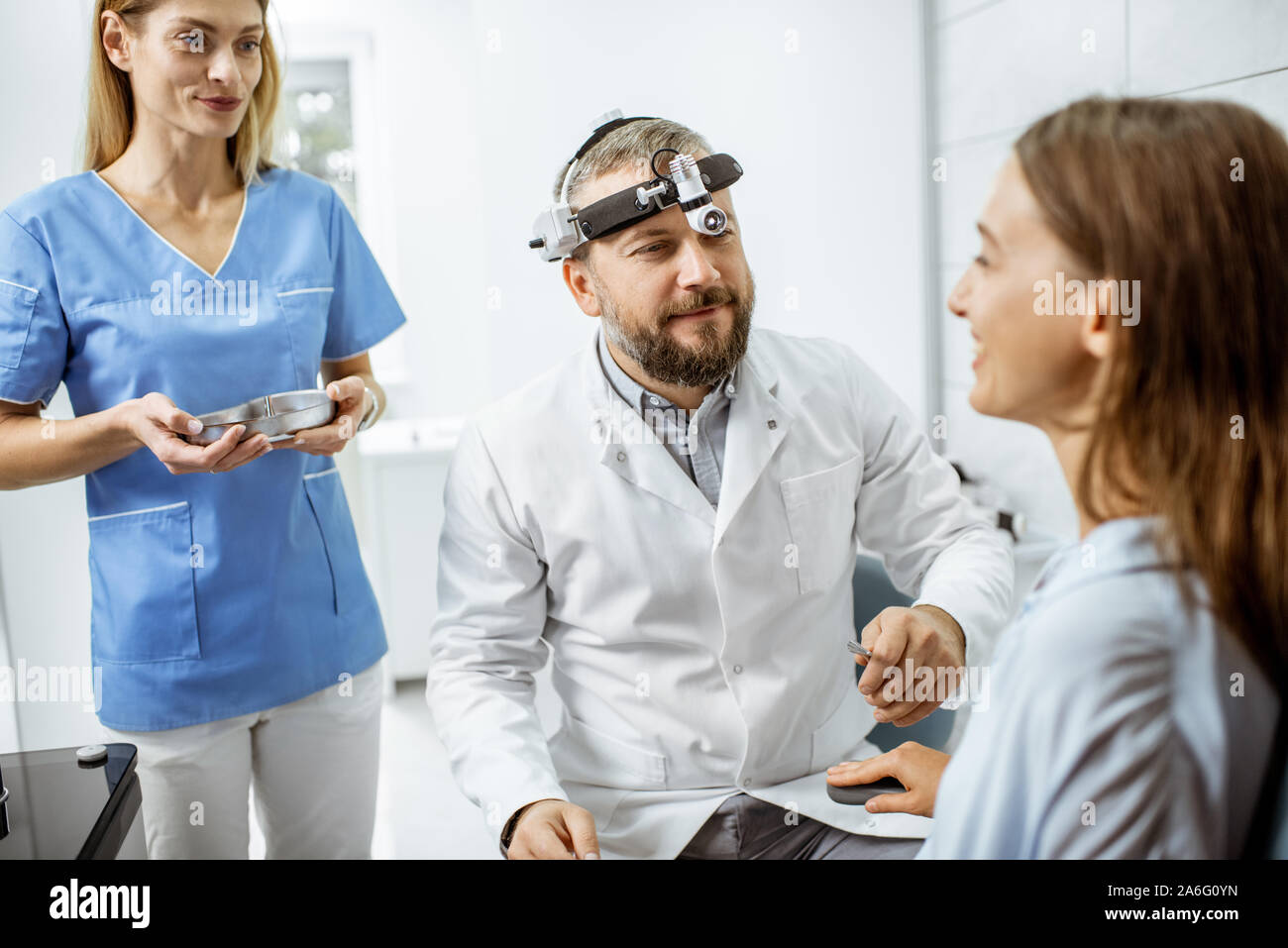 Patient with senior otolaryngologist and female assistant in ENT office ...