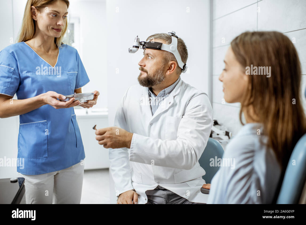 Patient with senior otolaryngologist and female assistant in ENT office ...