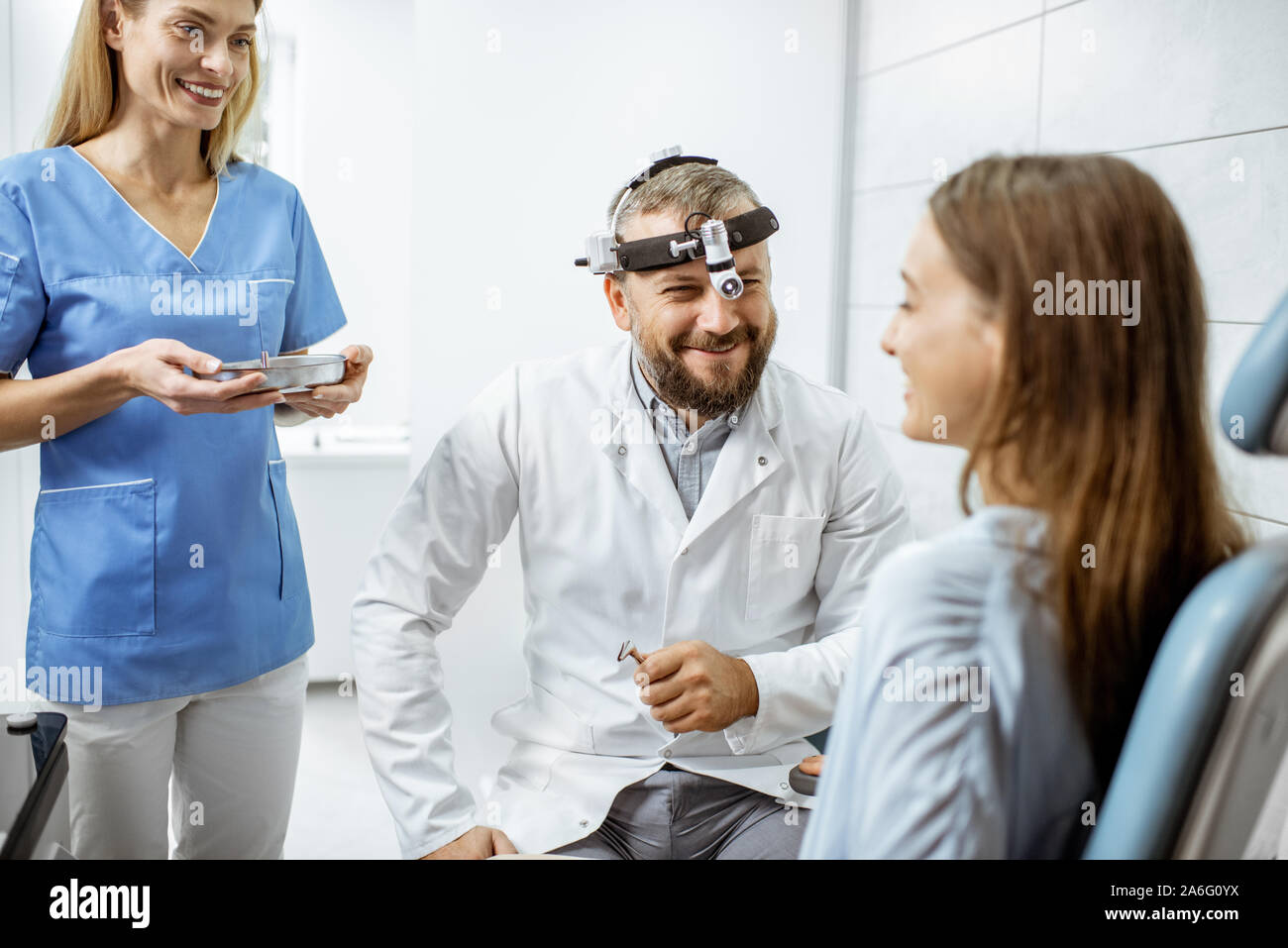 Patient with senior otolaryngologist and female assistant in ENT office ...