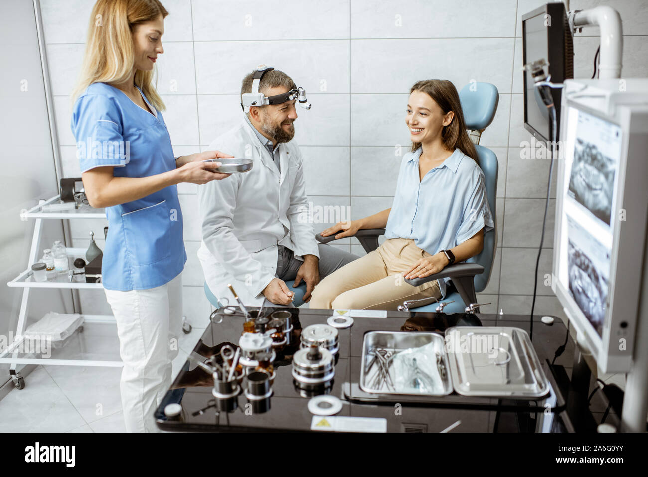 Patient with senior otolaryngologist and female assistant in ENT office ...