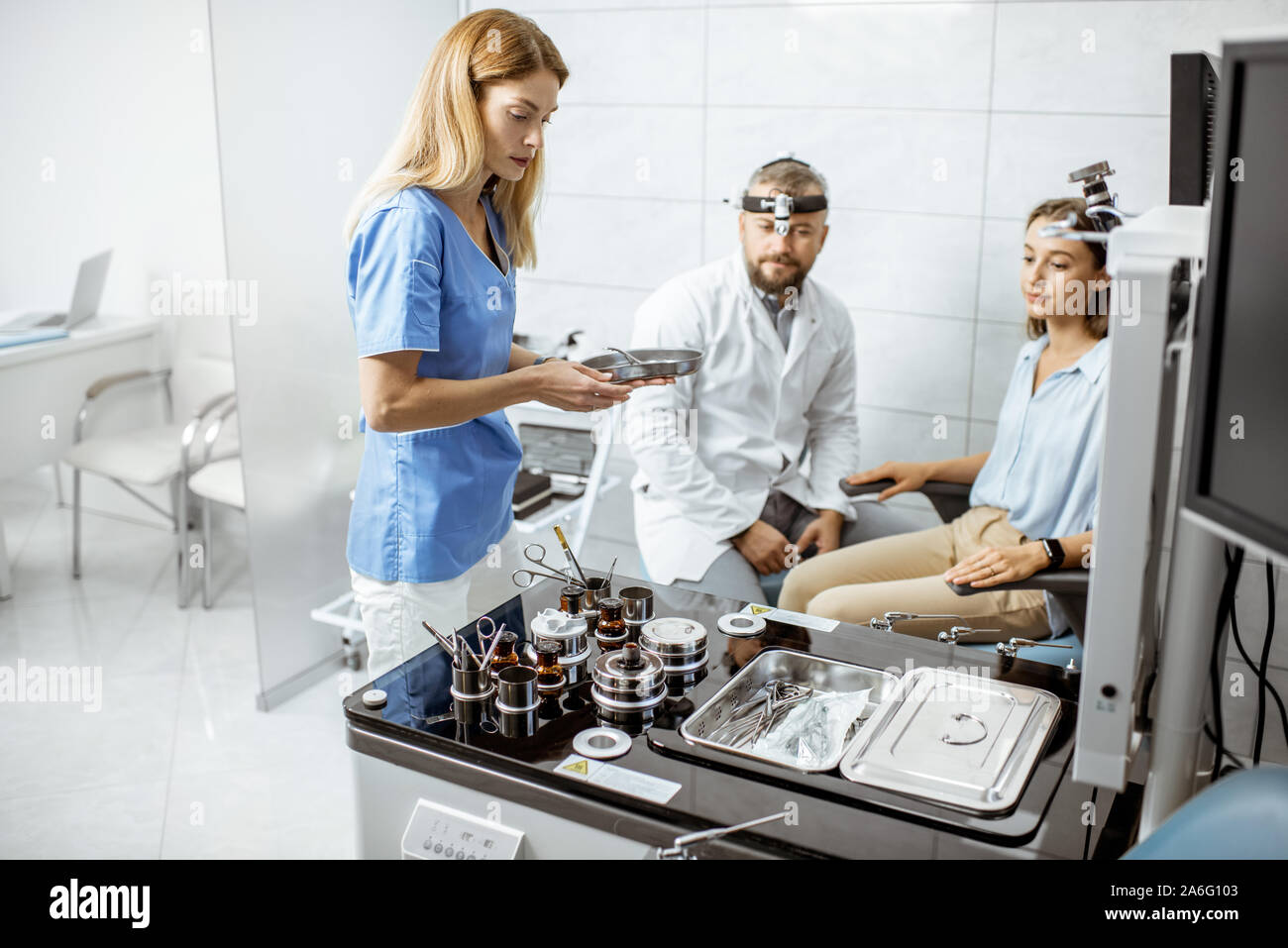 Patient with senior otolaryngologist and female assistant in ENT office ...