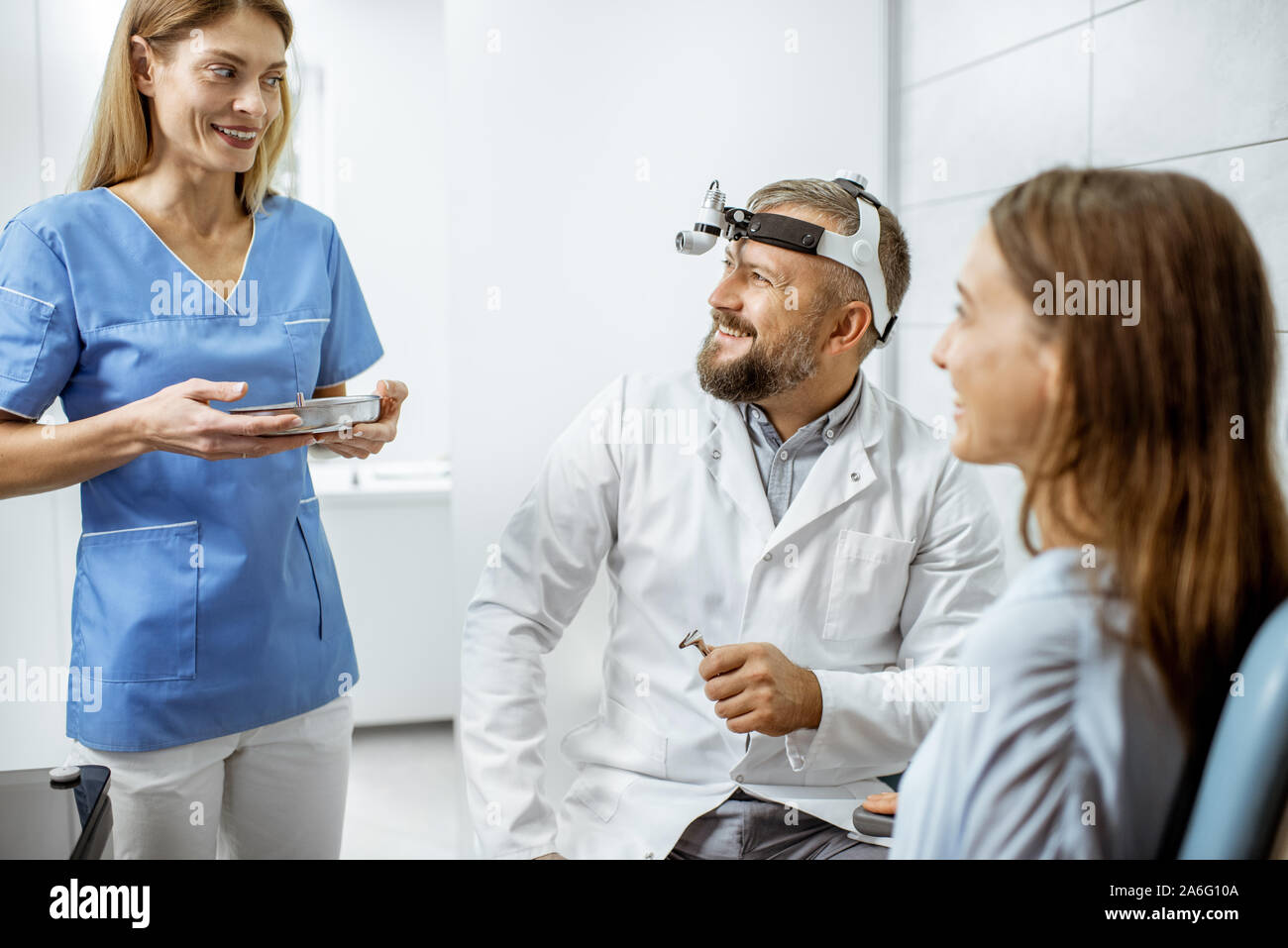 Patient with senior otolaryngologist and female assistant in ENT office ...